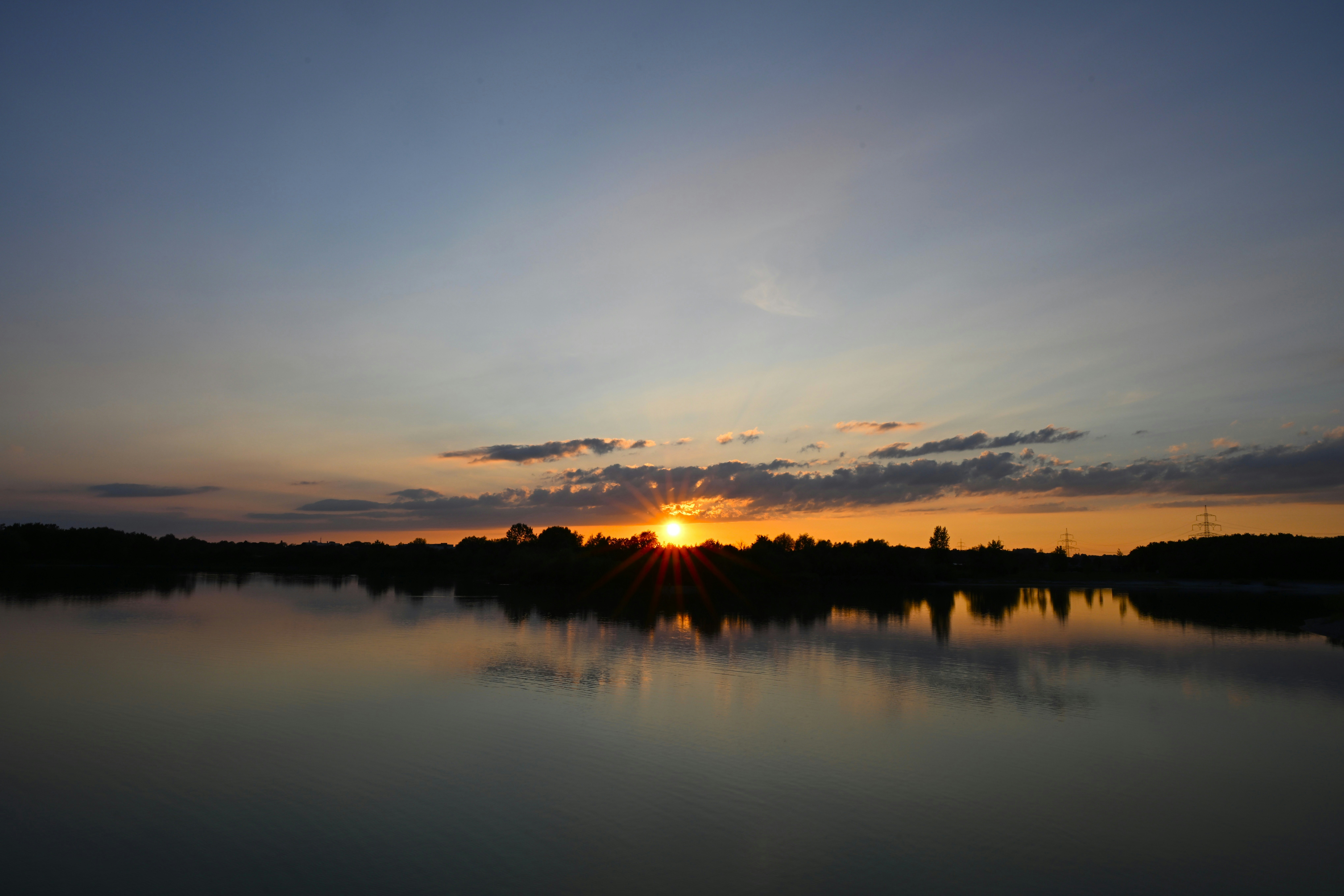 Sunlit Horizon Over Quiet Lake at Dusk