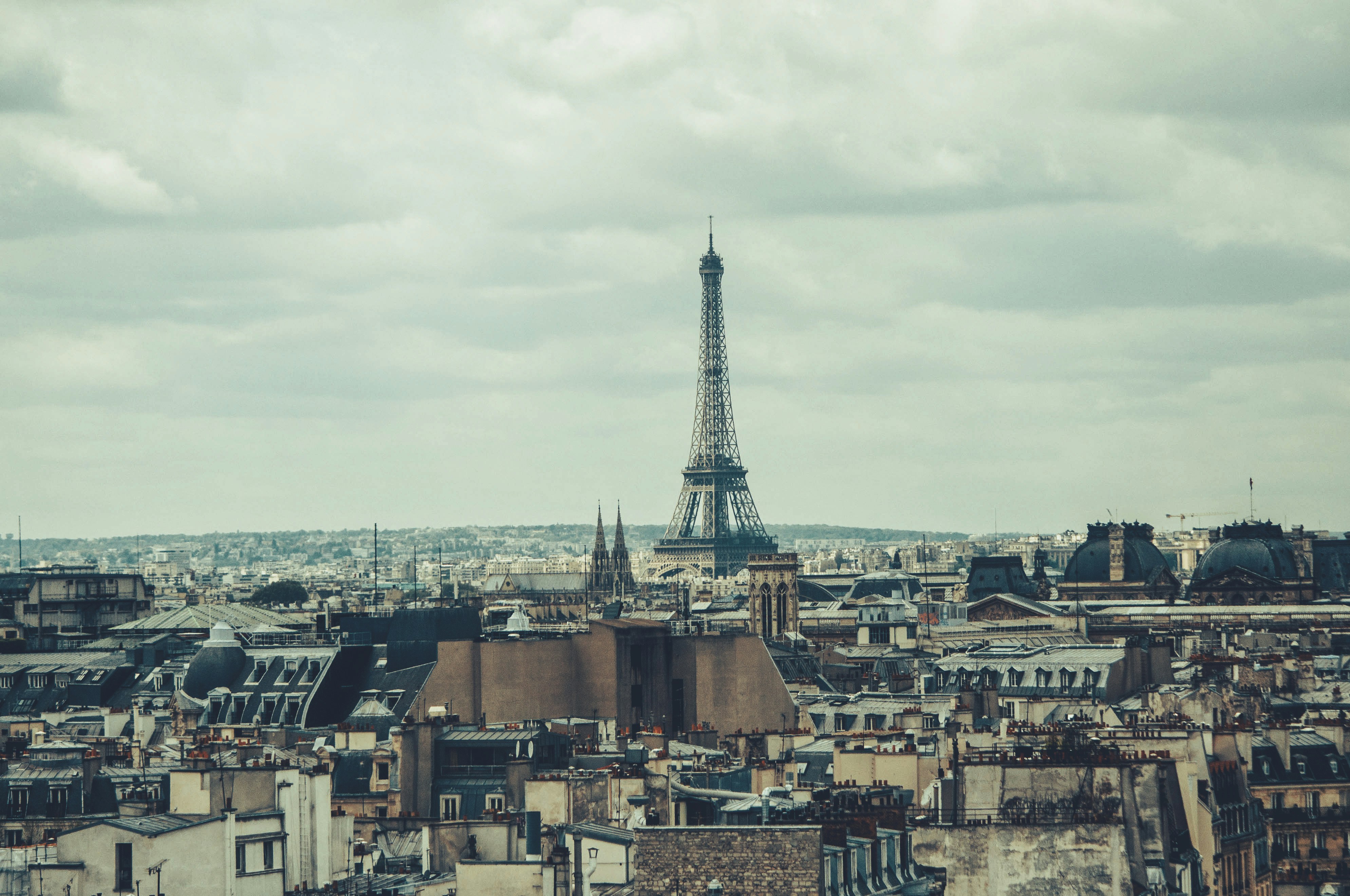 Paris View, Cloud Day ( 2013 ) A sweeping cityscape of Paris under a blanket of soft, gray clouds, showcasing the dense Haussmann rooftops, distant monuments, and a serene, diffused light that gives the urban sprawl a quiet, romantic, and timeless atmosphere.