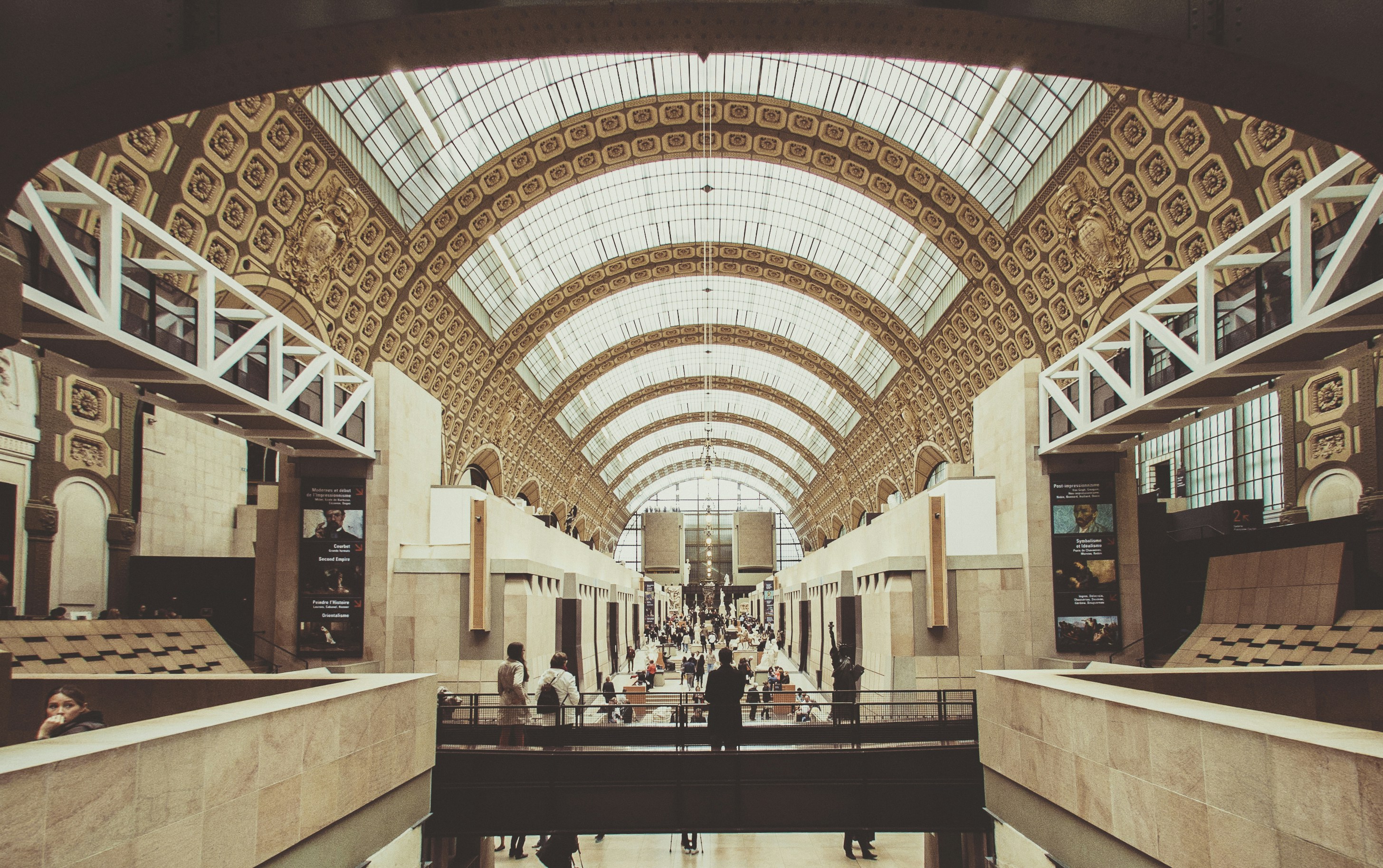 Musée d'Orsay in Paris ( 2013 ) A breathtaking interior view of the Musée d'Orsay in Paris, captured from inside its magnificent former railway station. The composition highlights the grand vaulted glass ceiling, the massive industrial iron arches, and the sweeping gallery spaces filled with natural light. Classic sculptures and impressionist masterpieces are visible along the wide central nave, creating a perfect harmony between 19th-century industrial architecture and world-class fine art, evoking a timeless cultural and museum atmosphere.