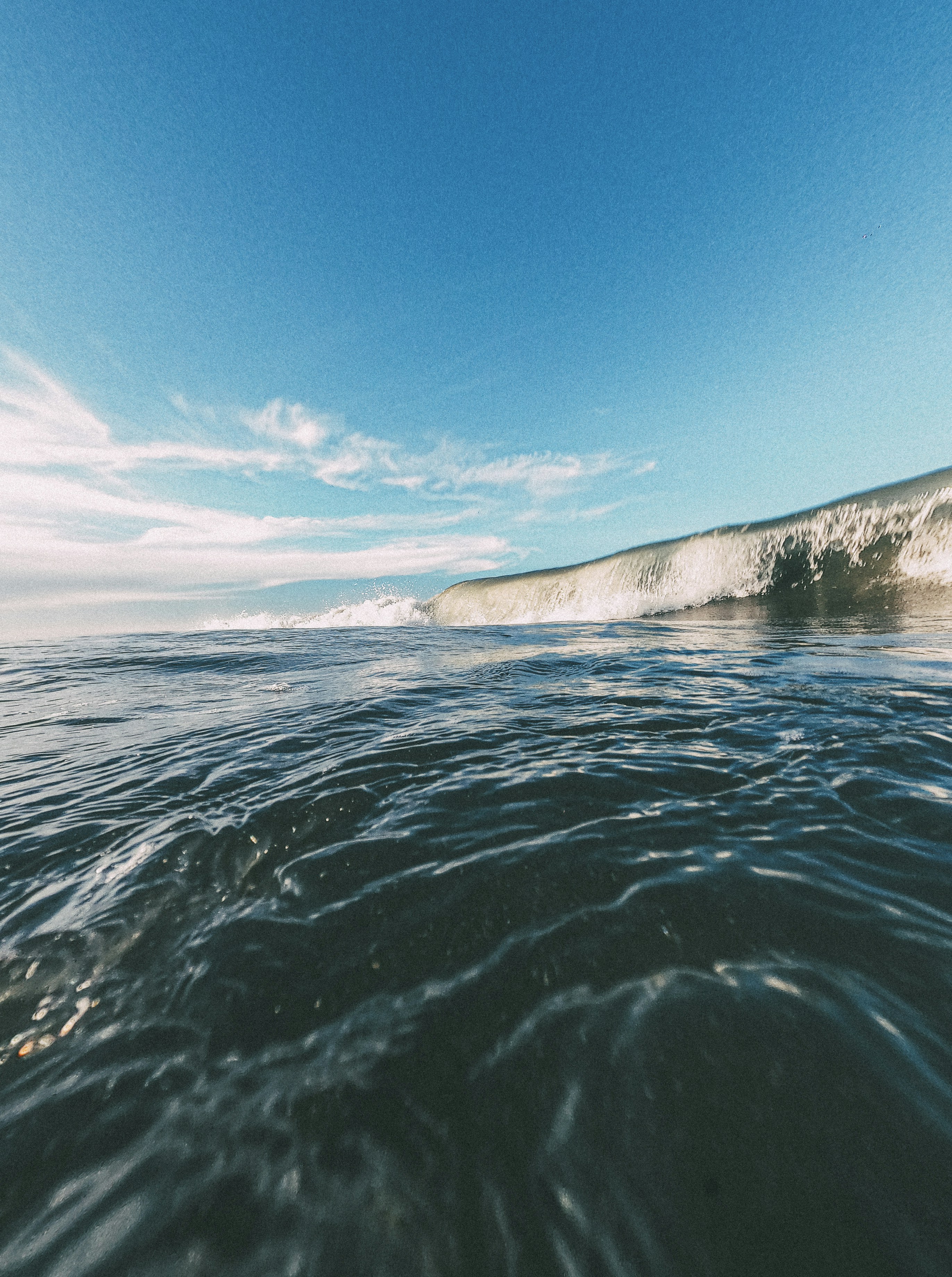 An abstract and fluid composition capturing the dark, dynamic shapes of ocean waves from an internal, immersive perspective, showing rolling water textures, deep blues, and the powerful, chaotic motion of nature.