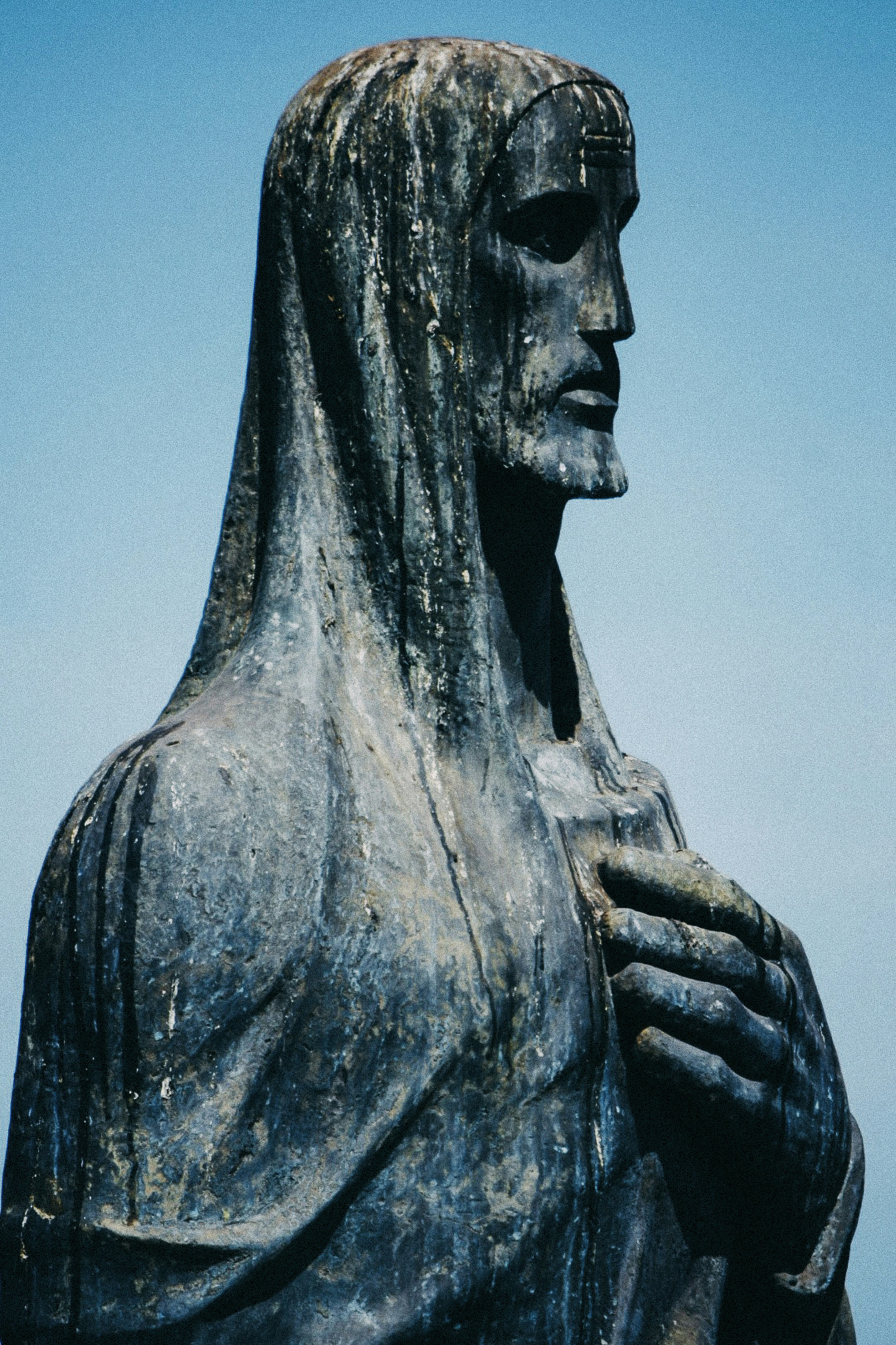 Stone Sentinel: A Weathered Statue Reaching Toward the Sea