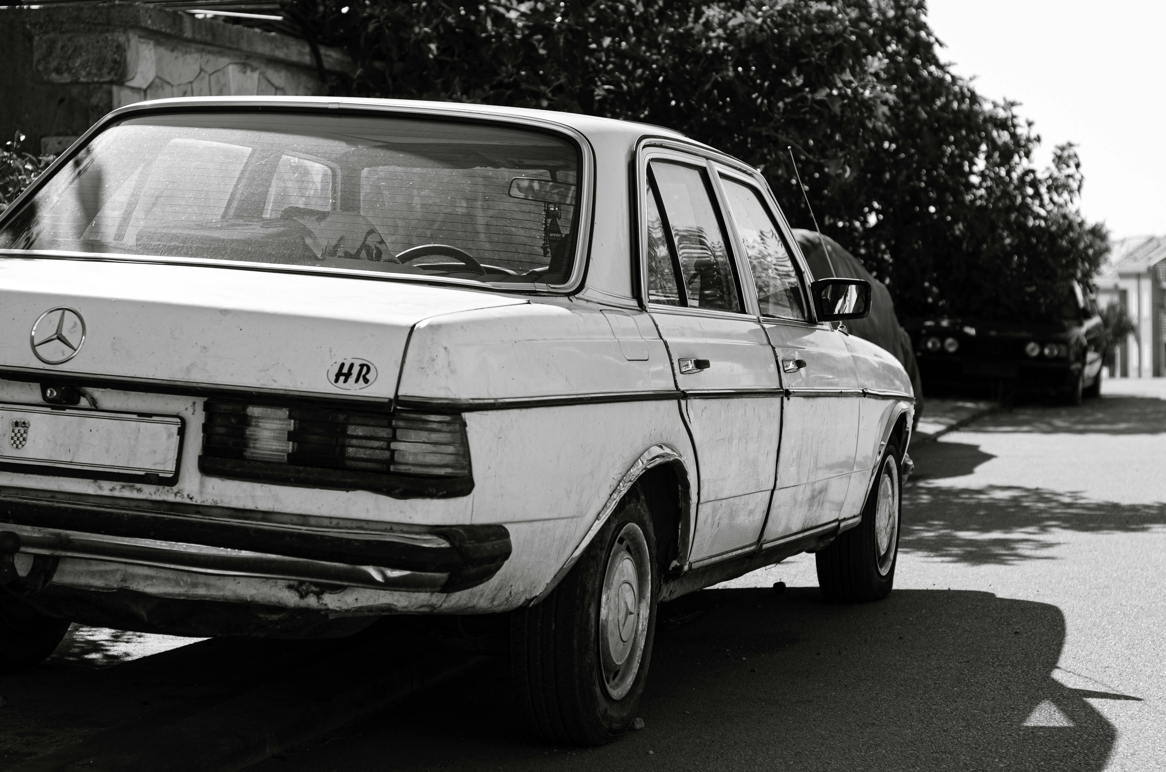 Backstreet Residue: An Aged Mercedes Resting in Shadowed Light