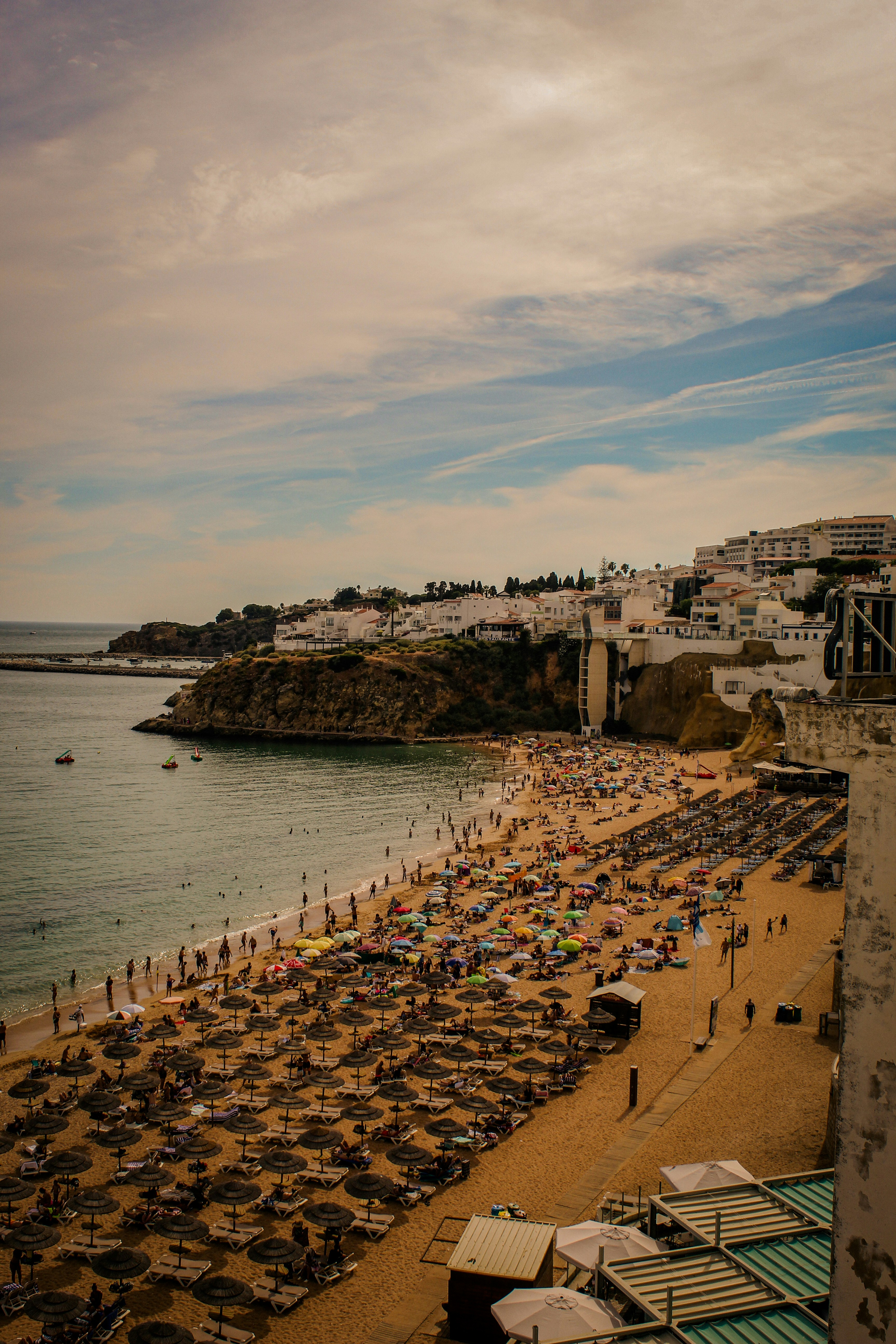 Sunlit Spanish Beach: A Tapestry of Loungers and Cliffside Homes