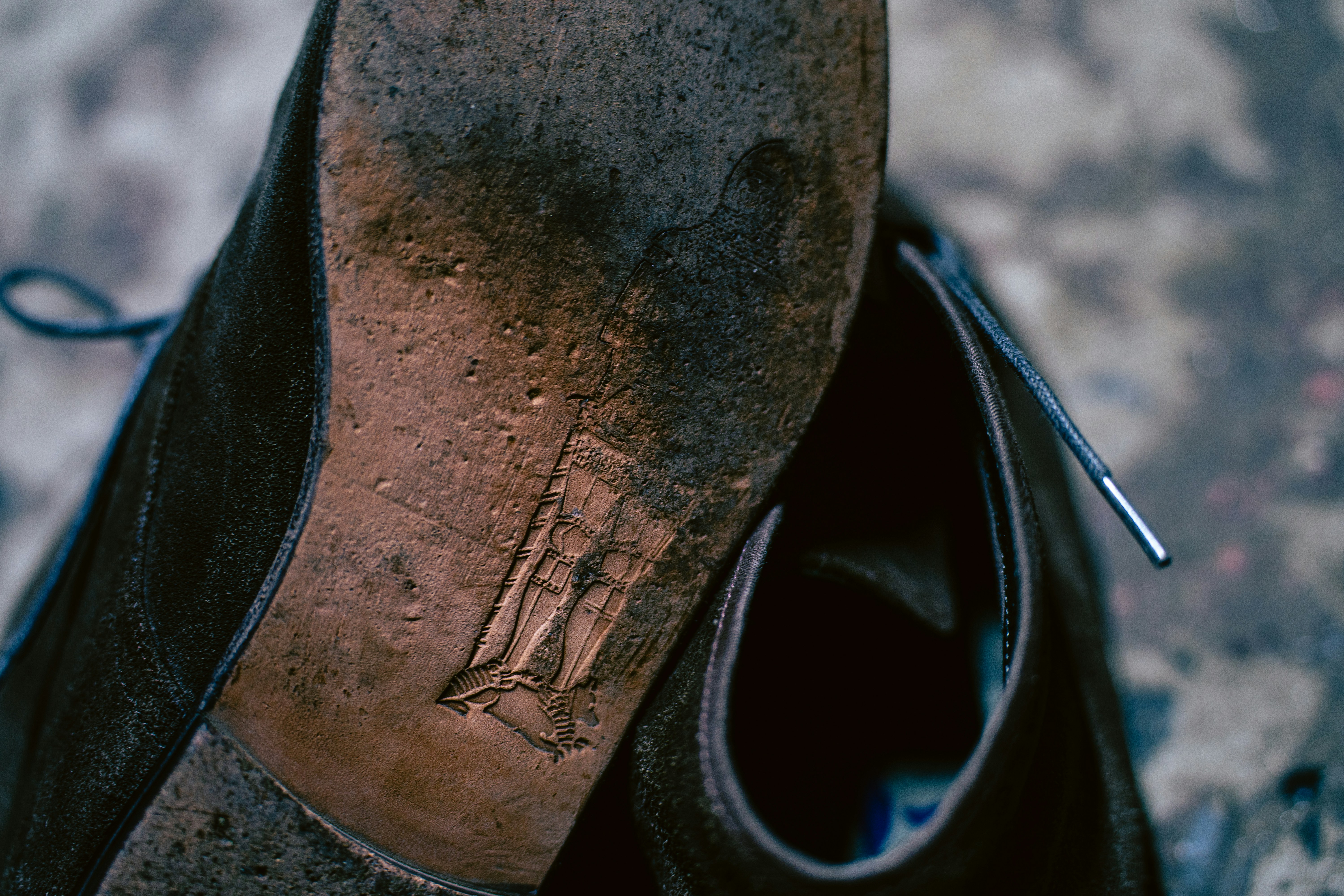 Boot sole with worn engraving resting on a dusty edge