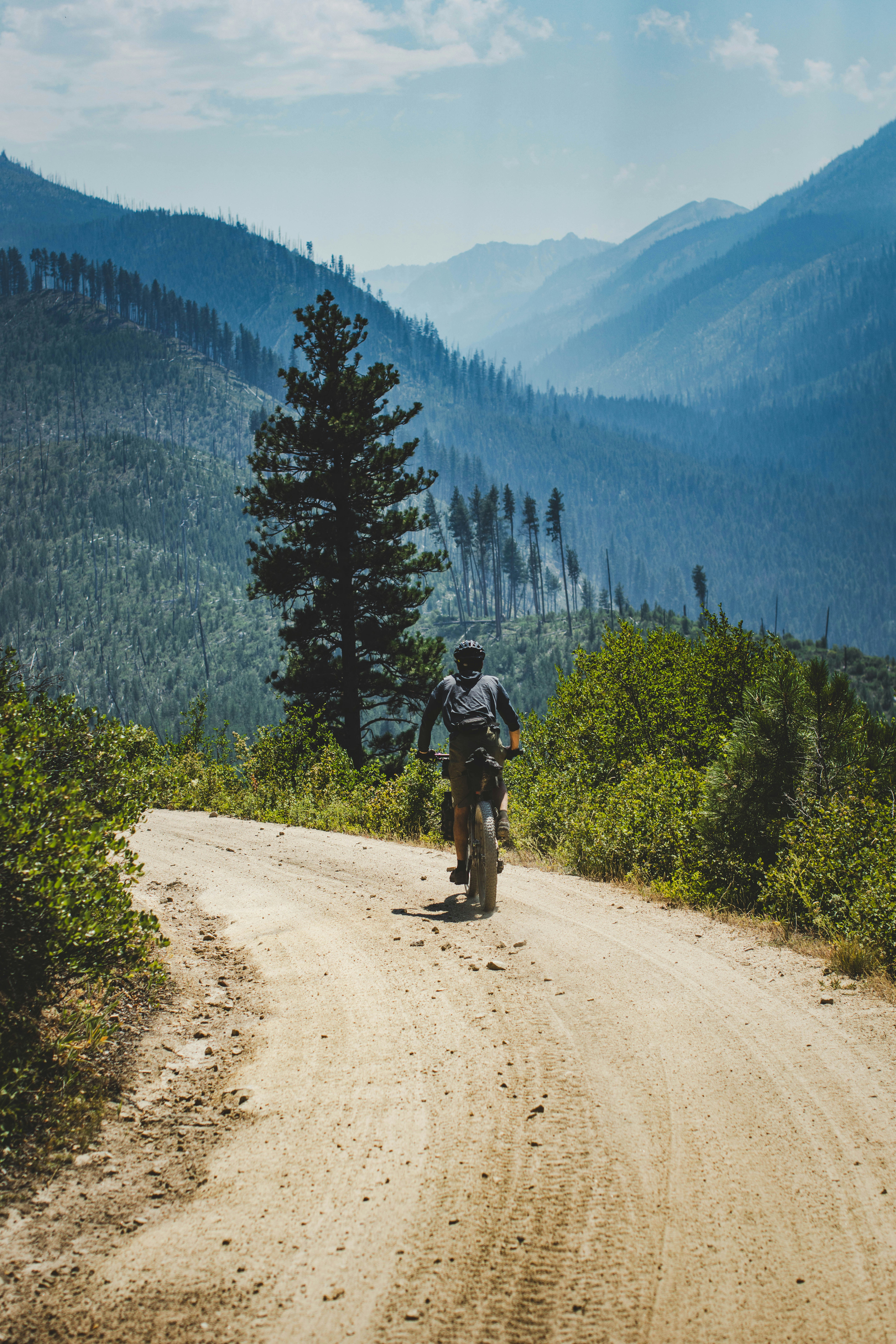 Mountaintop Ascent: cyclist carving through a sunlit valley