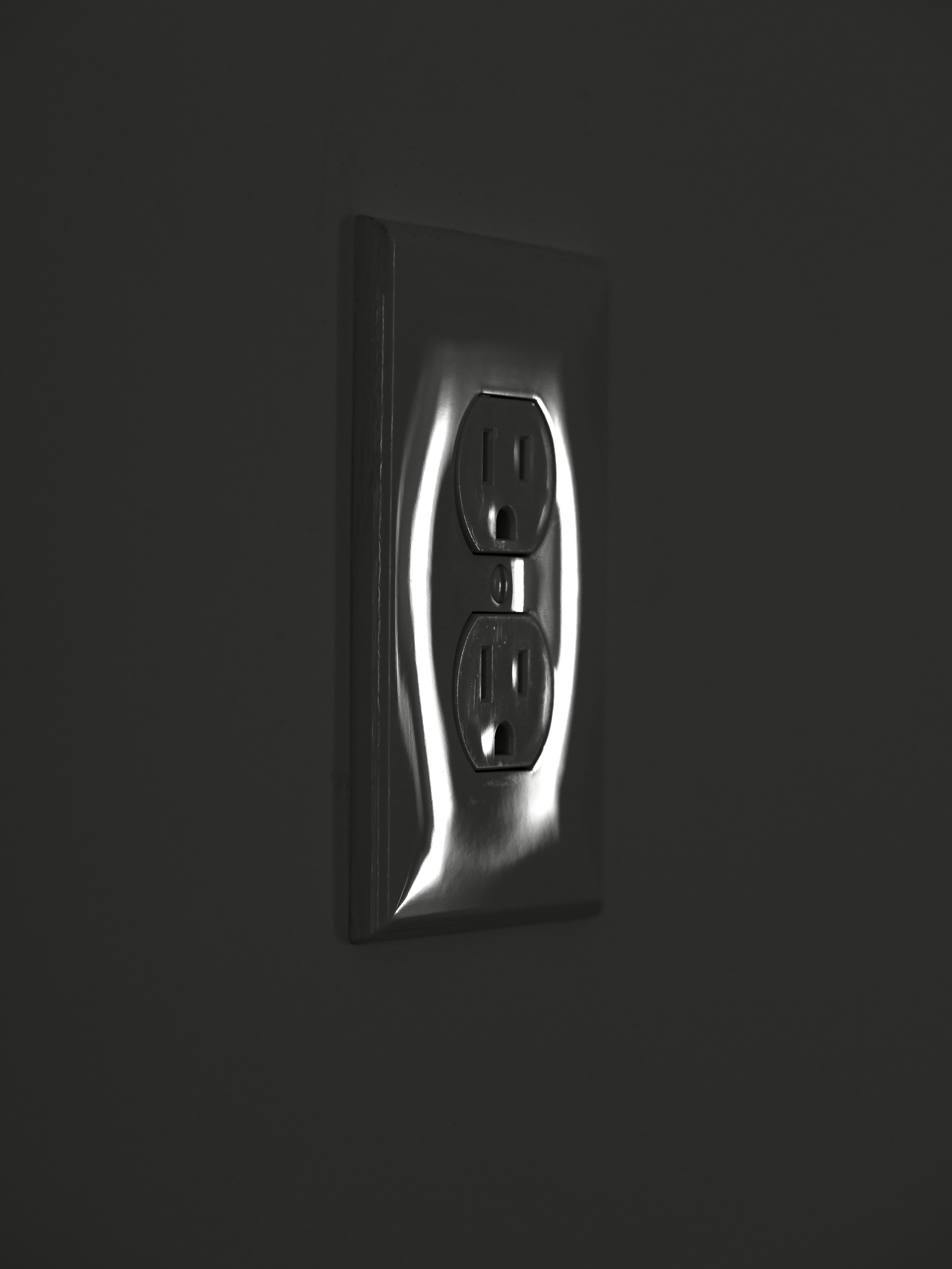 Hidden Power: A Quiet Wall Outlet Emerges from Shadow