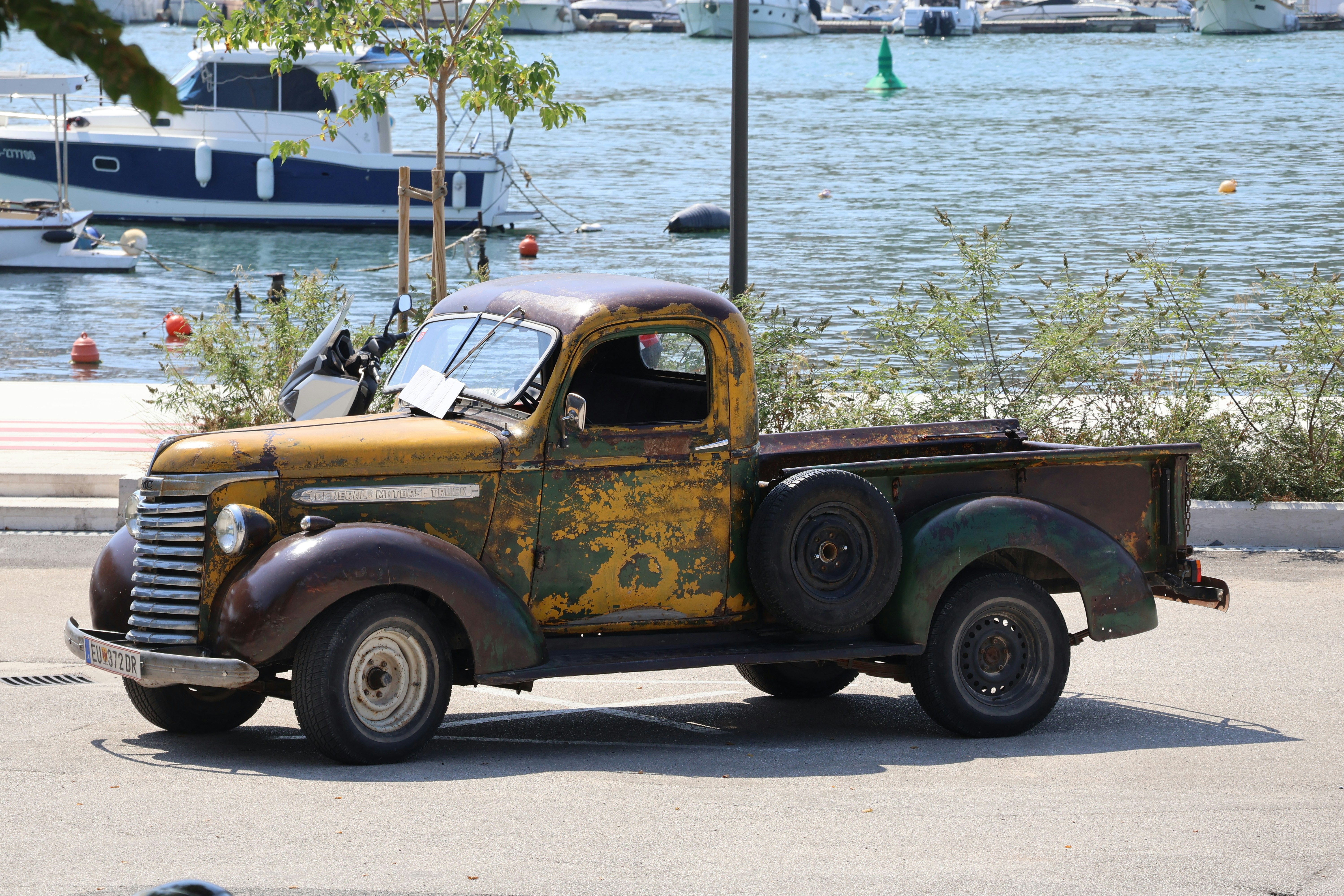 Weathered Workhorse: Rusted Pickup Resting by the Harbor