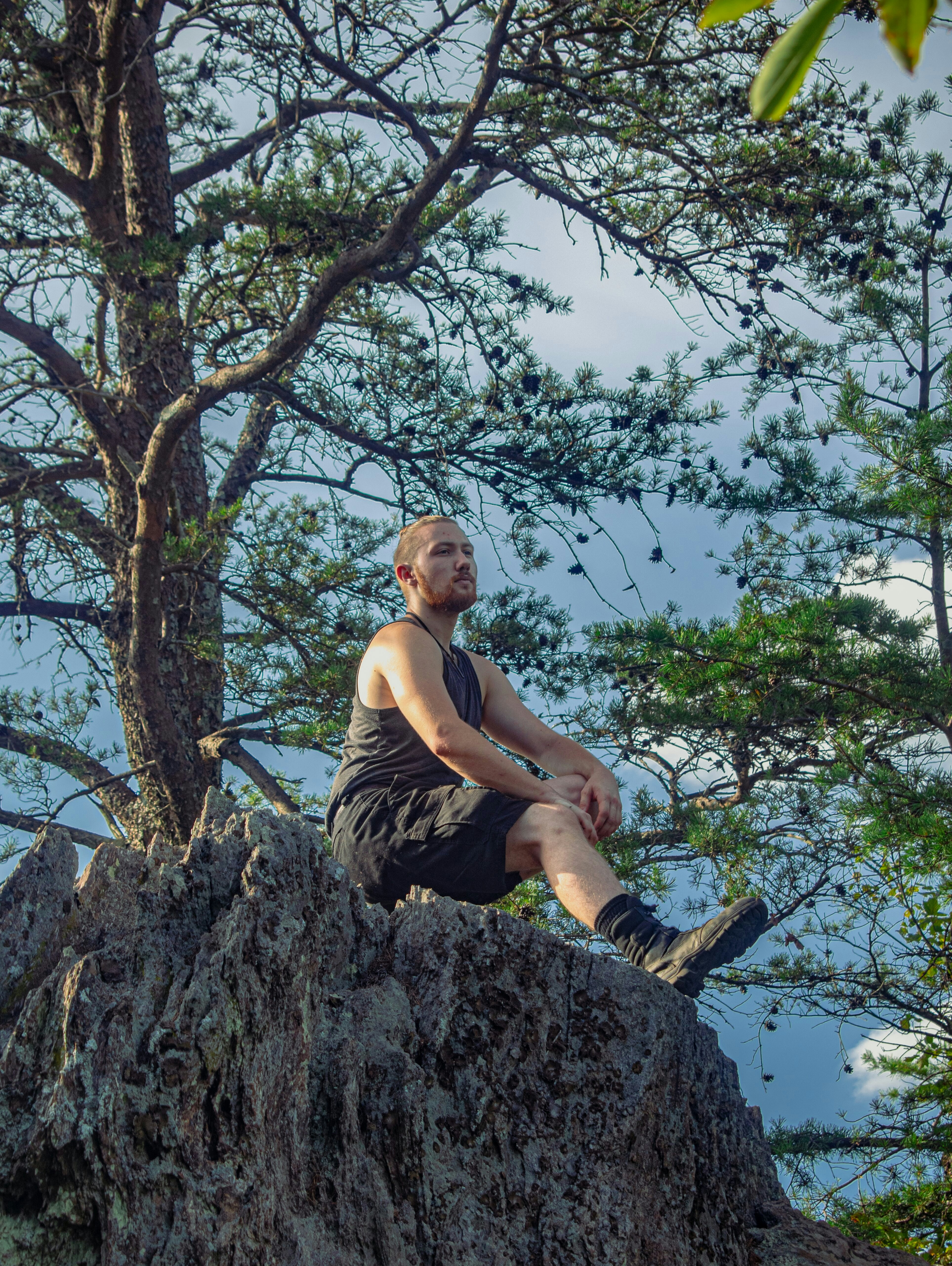 Sitting Above the World: Man Contemplates from a Rocky Outcrop