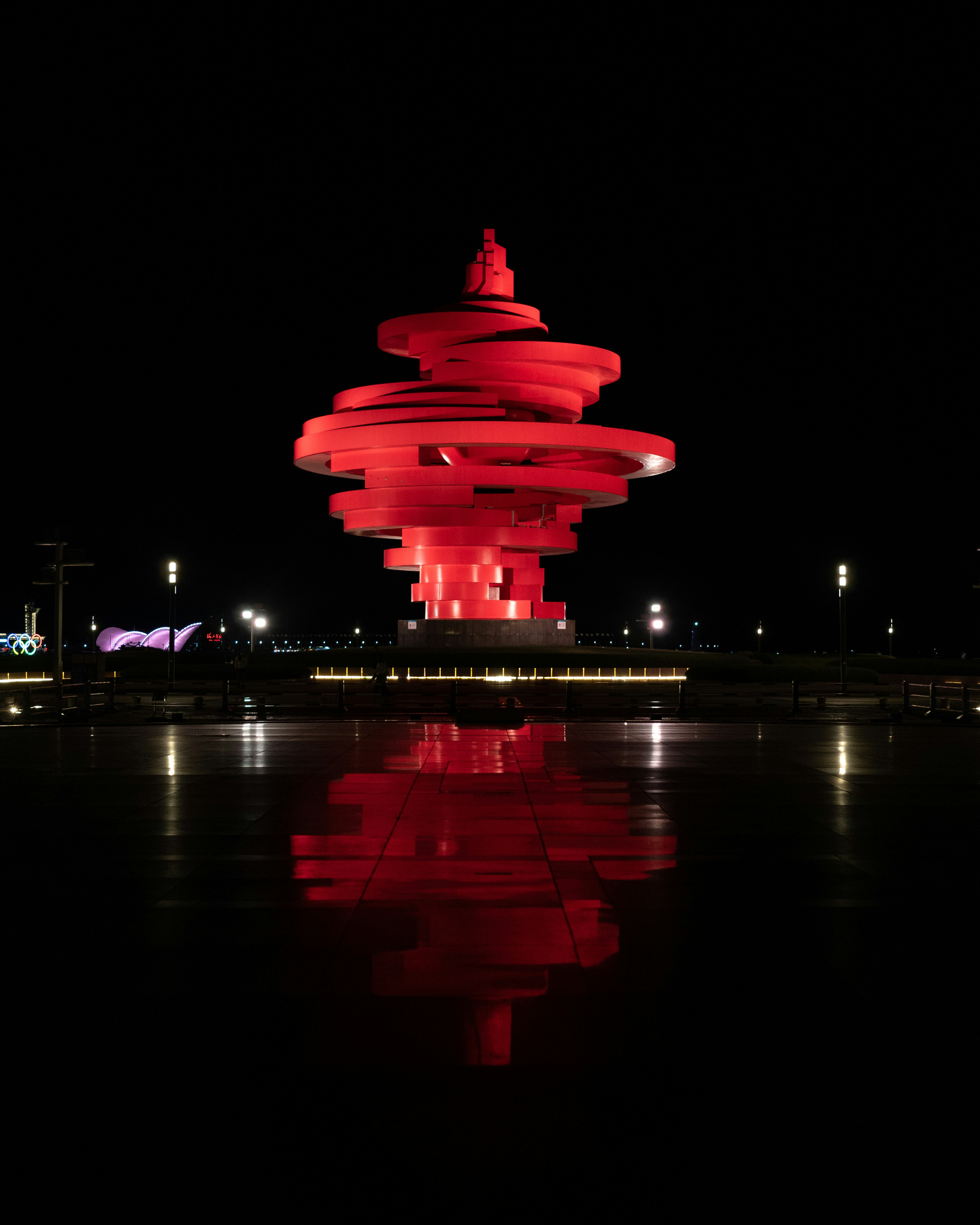 Red Spiral Monument at Night: Reflections over a Quiet Plaza
