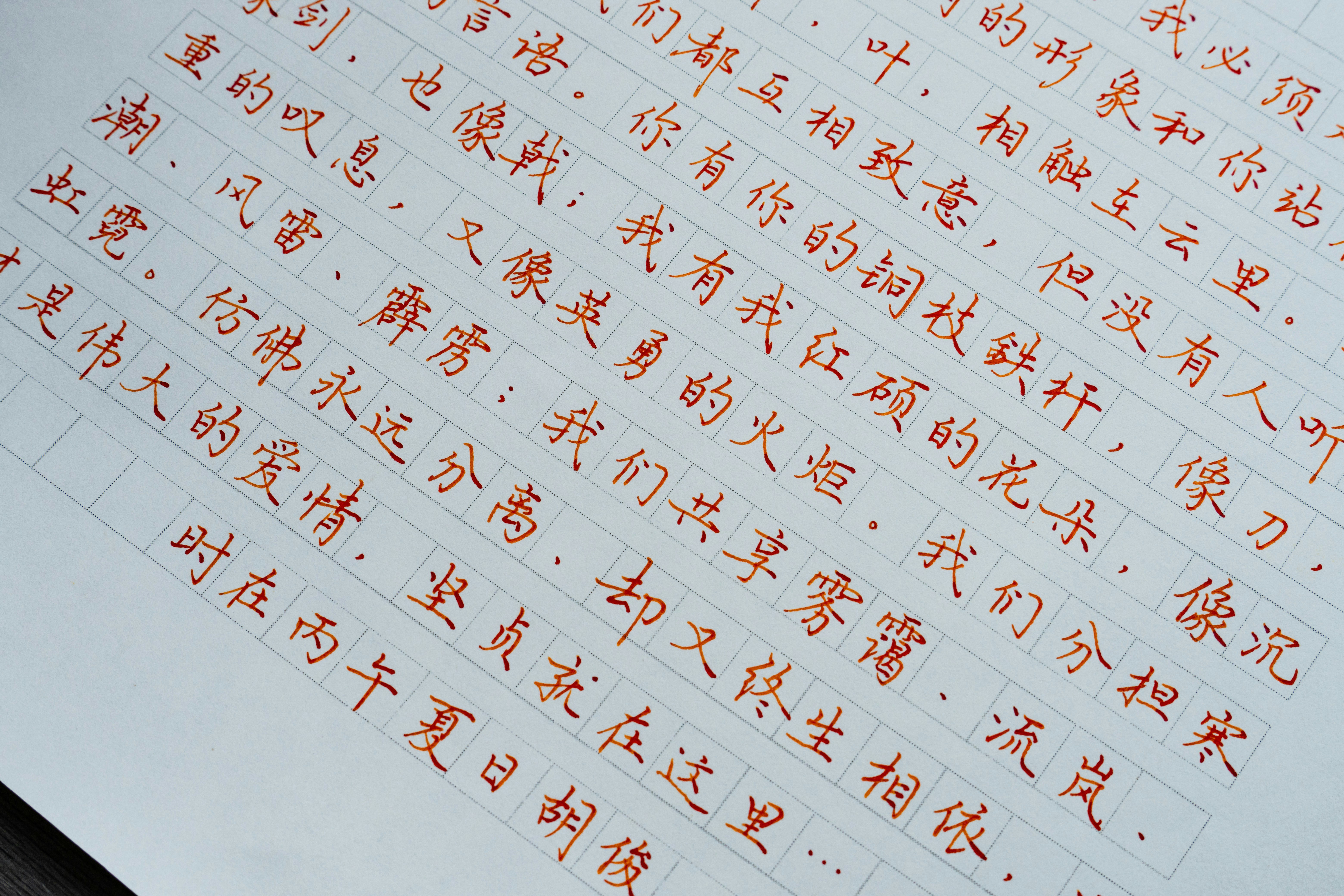 Red Script in Rows: Close-up of Handwritten Text on White Paper