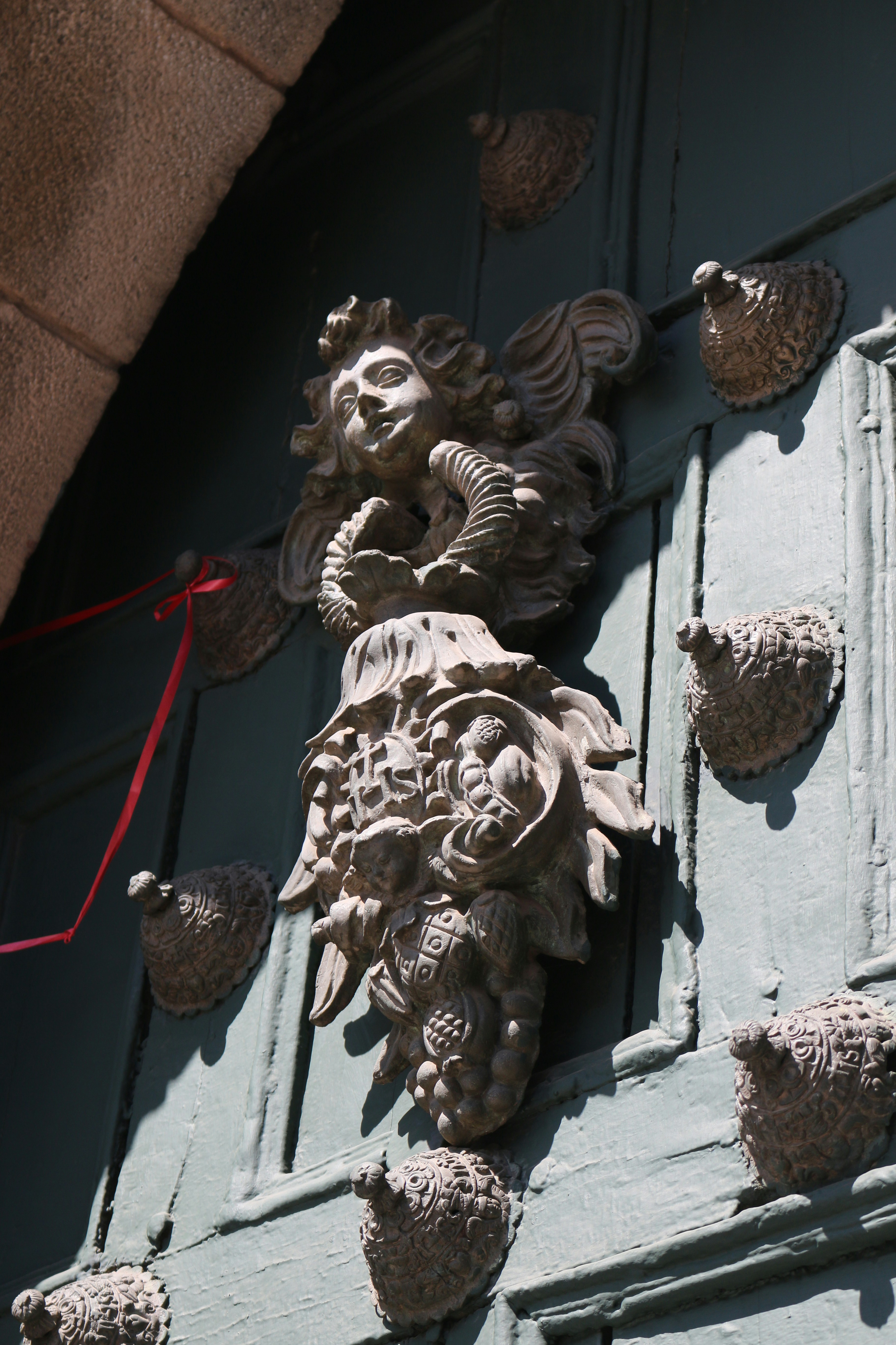 Stone Guardian with Floral Crest Guarded by Gilded Entrances