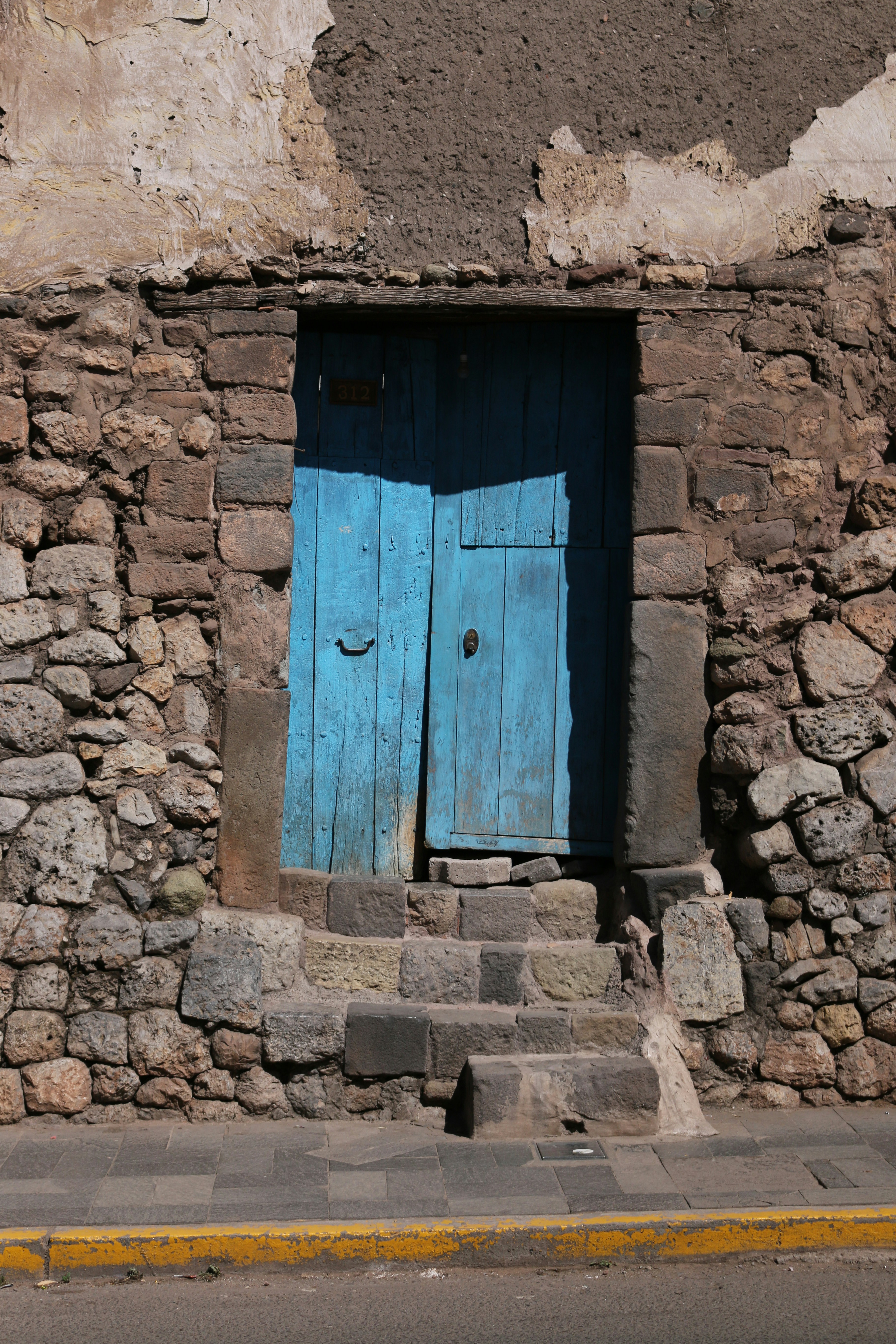 Weathered Blue Door Framed by Rough Stone Facade
