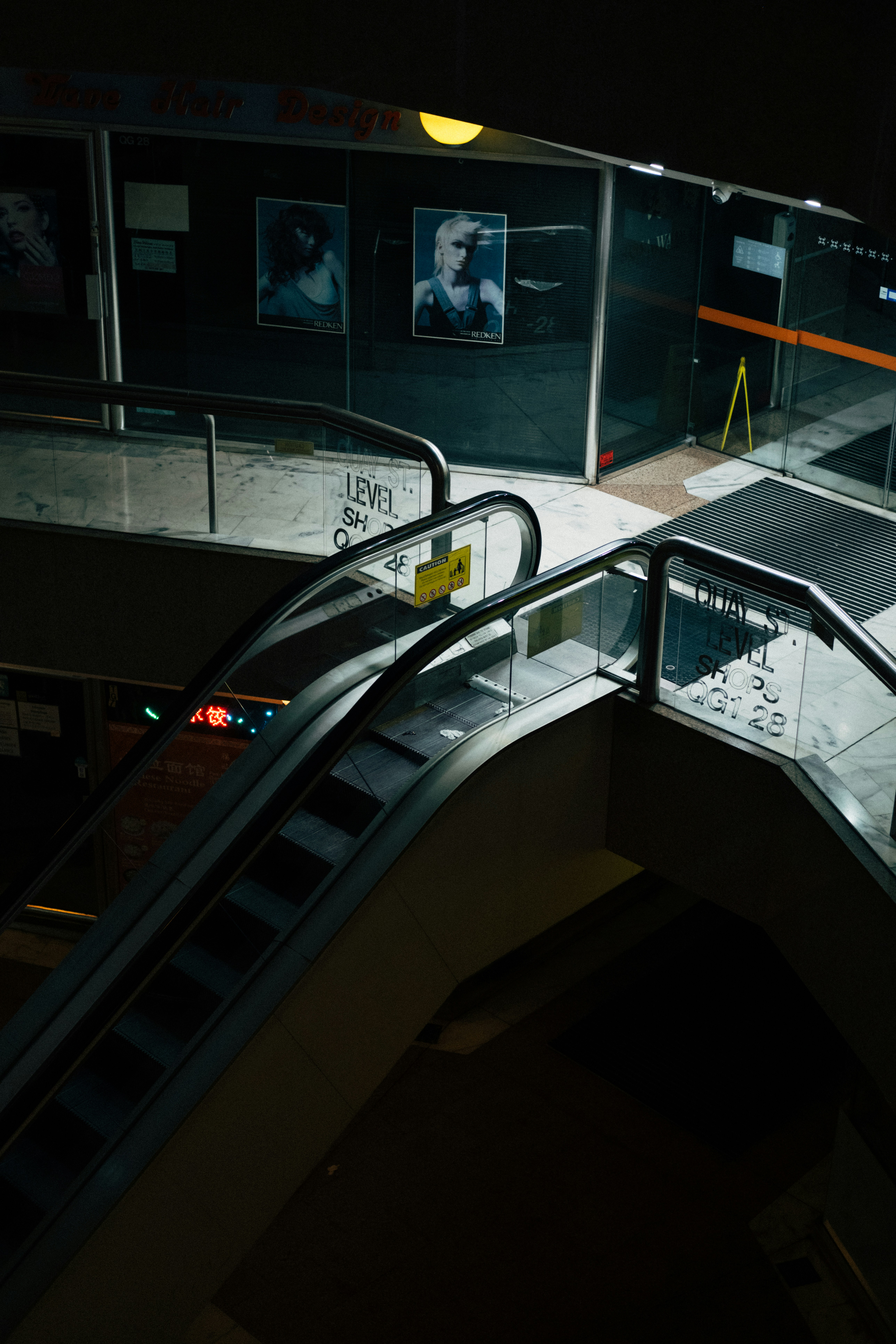 Urban Escalator Silence: Neon Hallway Beneath Glass