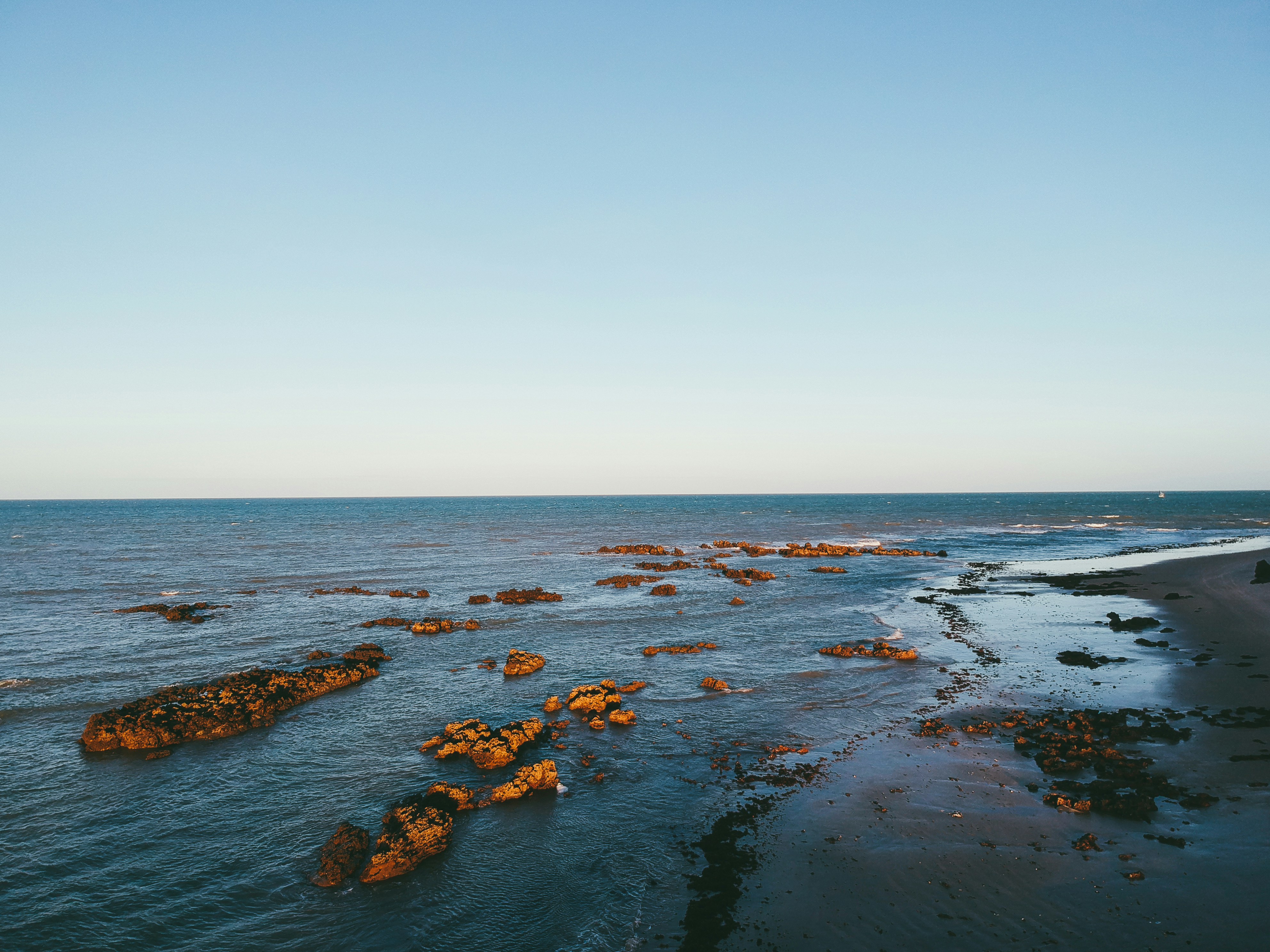 Aerial Drone View of Touros Beach, Rio Grande do Norte – Vila Galé ( 2025 ) A breathtaking aerial drone perspective of the pristine coastline at Touros Beach, Rio Grande do Norte, captured in 2025 near the Vila Galé resort. The sweeping composition showcases the vivid contrast between crystal-clear turquoise ocean waters, rolling white foam waves, and the golden sands of Brazil's northeastern shore. Palm trees and lush coastal vegetation frame the tropical landscape, while the endless horizon reflects the bright, sunny equatorial sky. This high-angle viewpoint captures the untouched natural