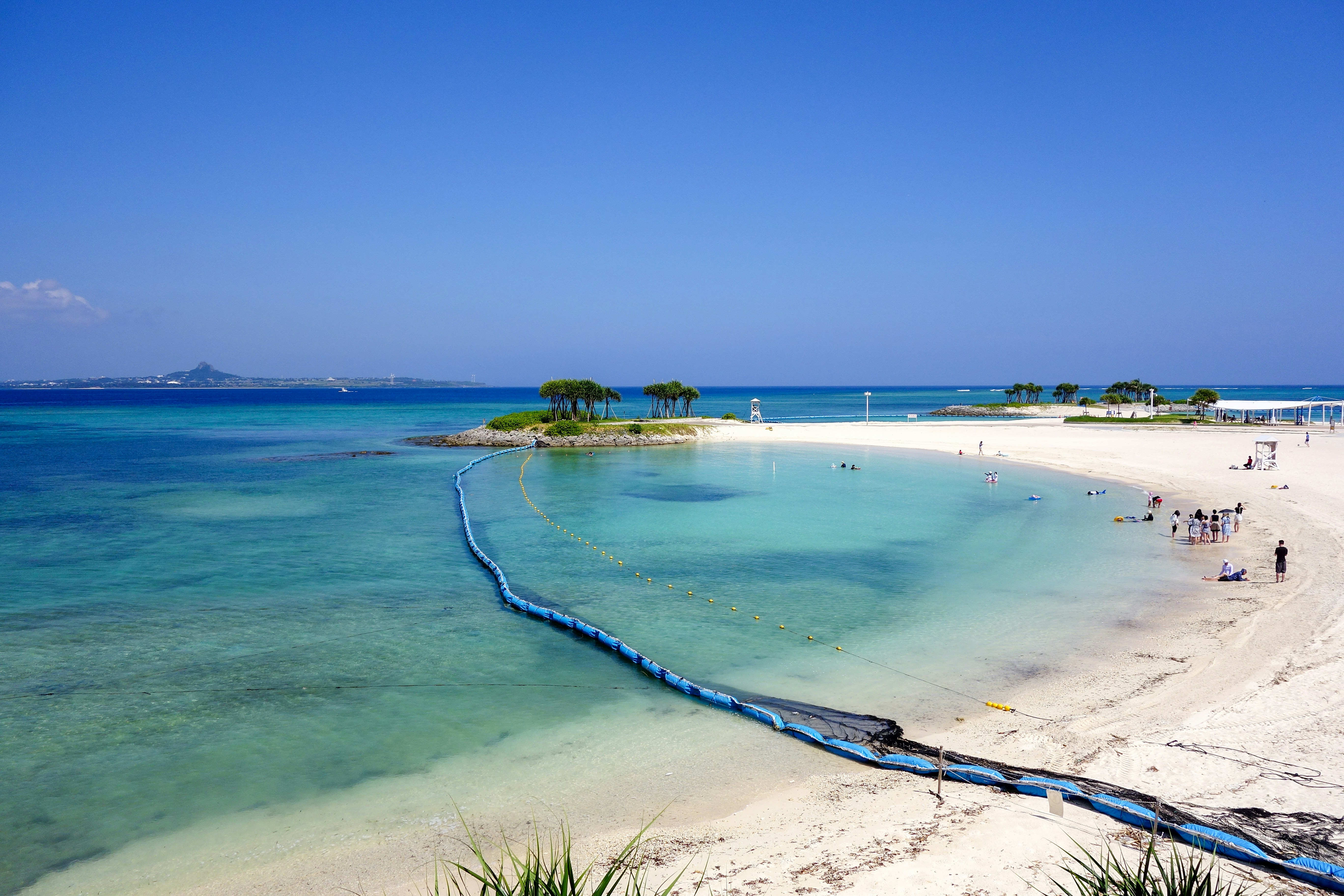 Curved Barrier: A Calm Lagoon Breach along a Sunlit Sandbar