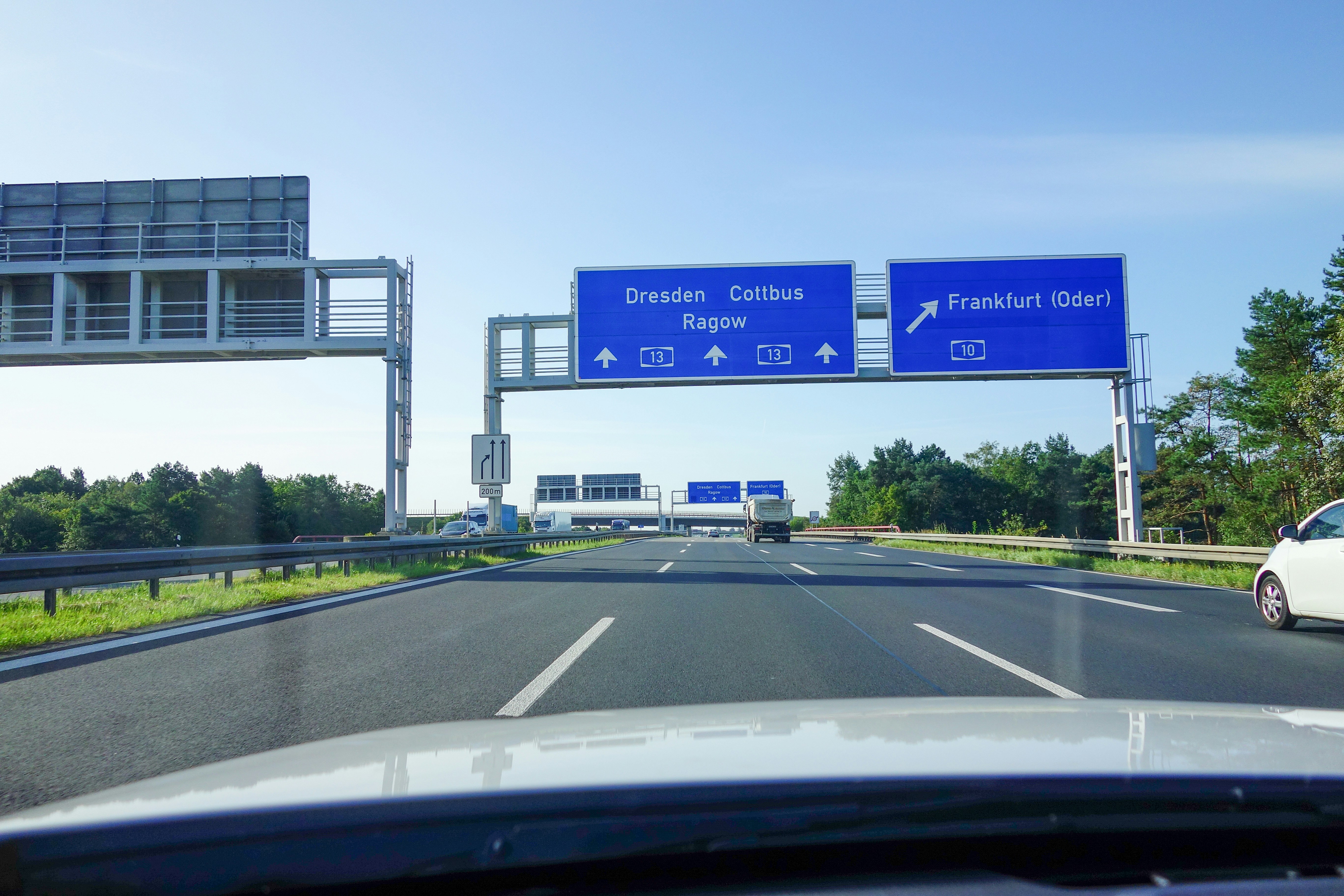 Highway Overpass as Compass: Blue Road Signs Guiding the Morning Drive