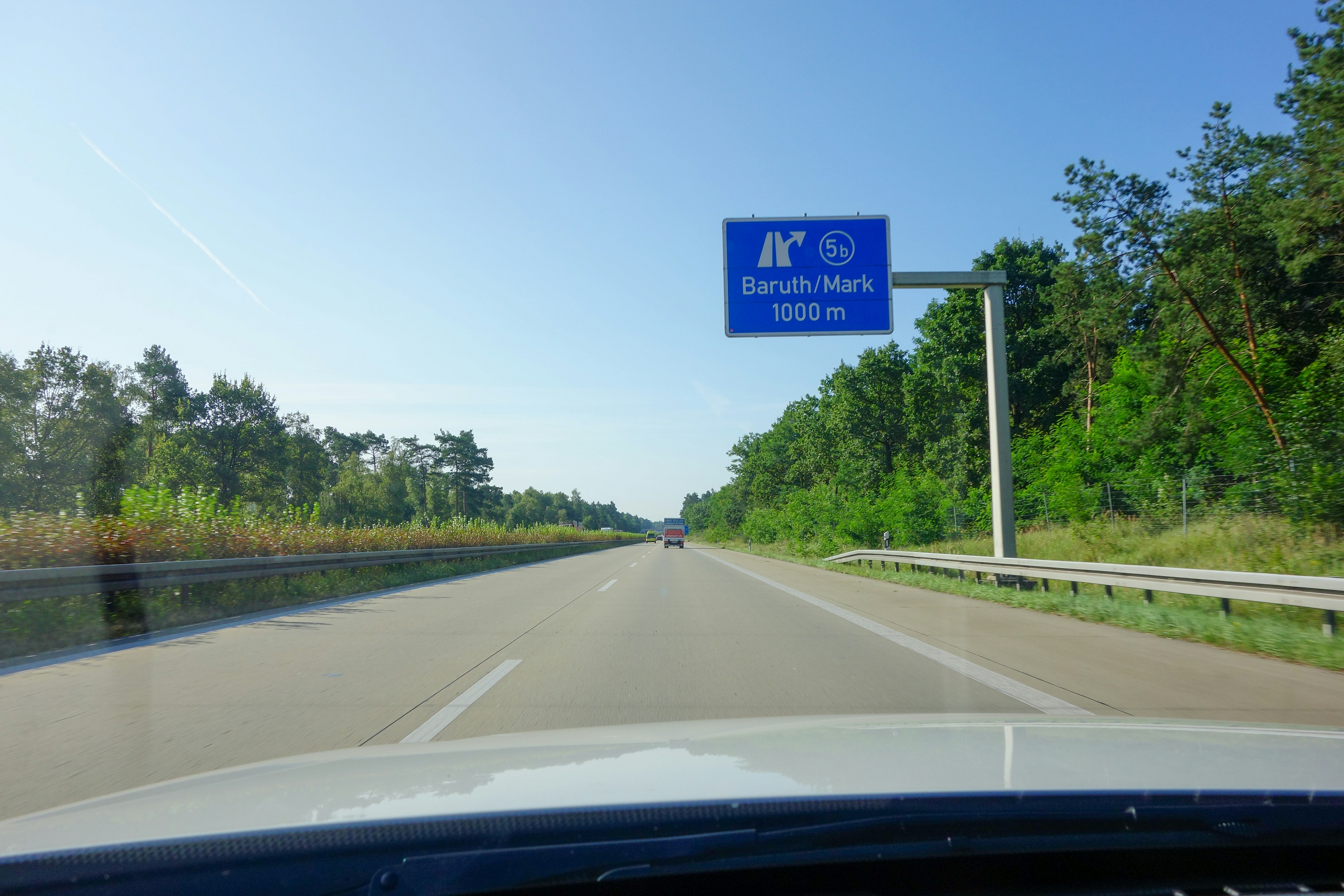Highway Horizon: Blue Sign Guiding the Long Drive