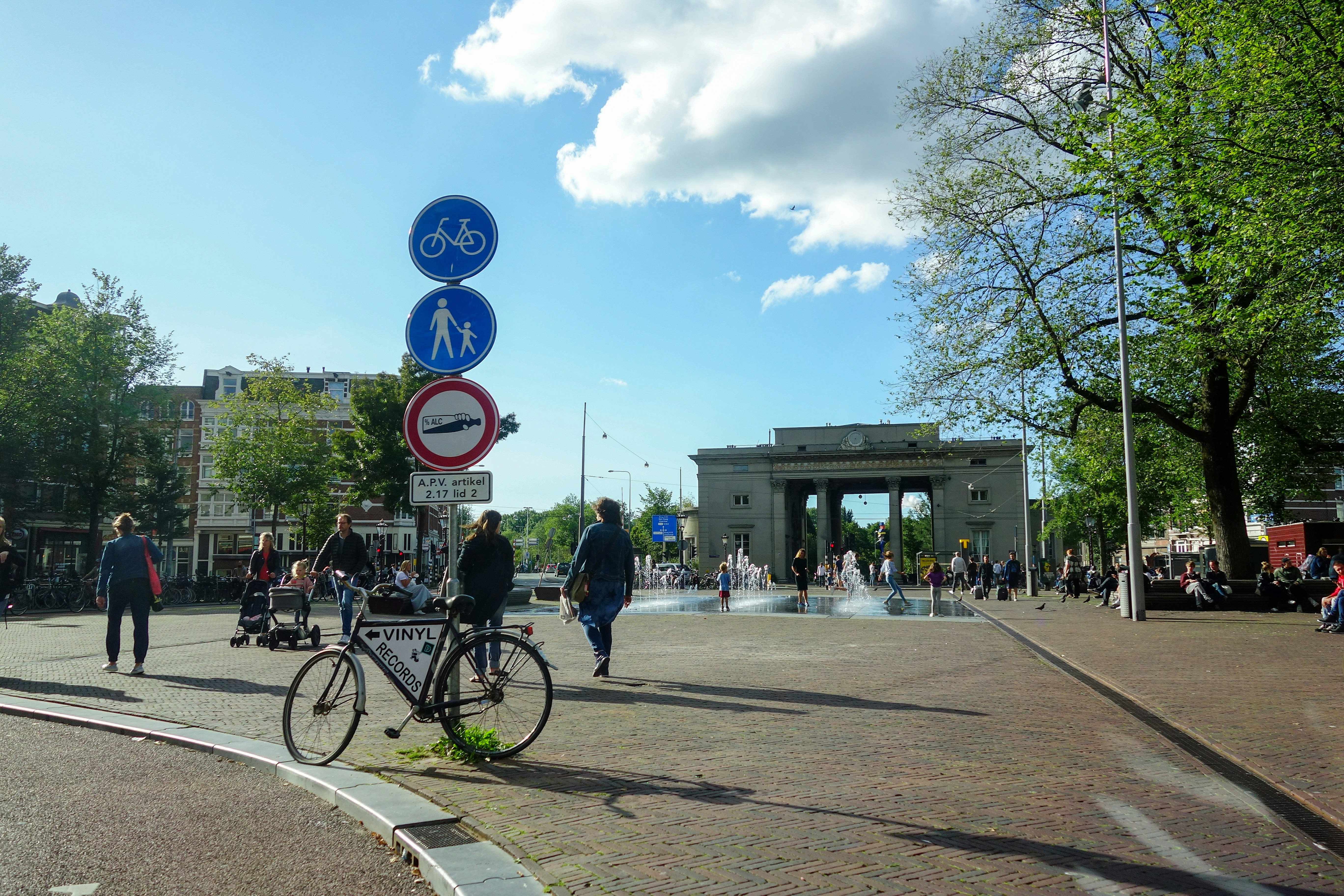 Bicycle Signpost and Fountain Courtyard at a Sunlit City Square