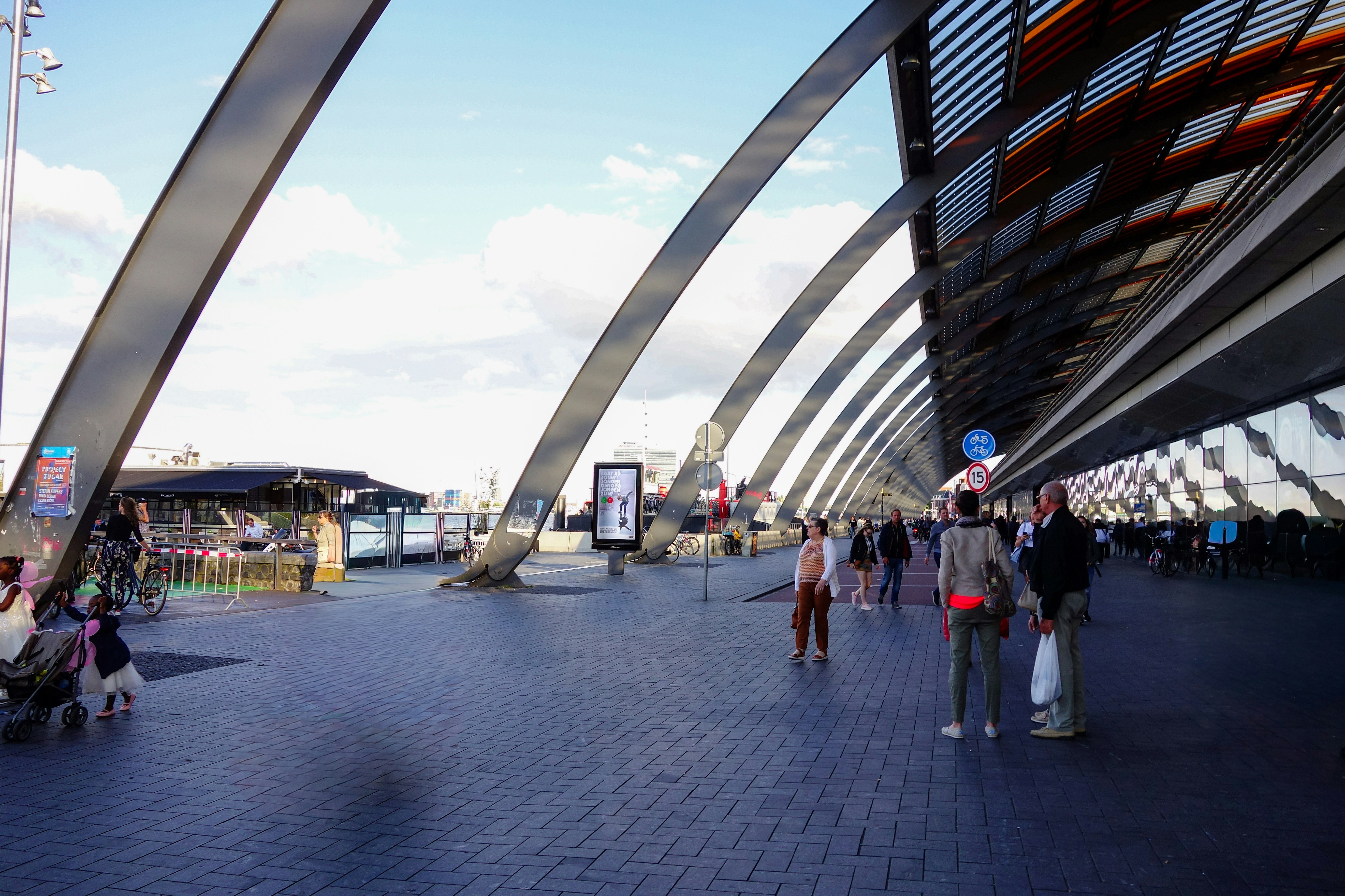 Curved Canopy, Station Platform, and Distant Pedestrians at a Modern Waterfront Walkway