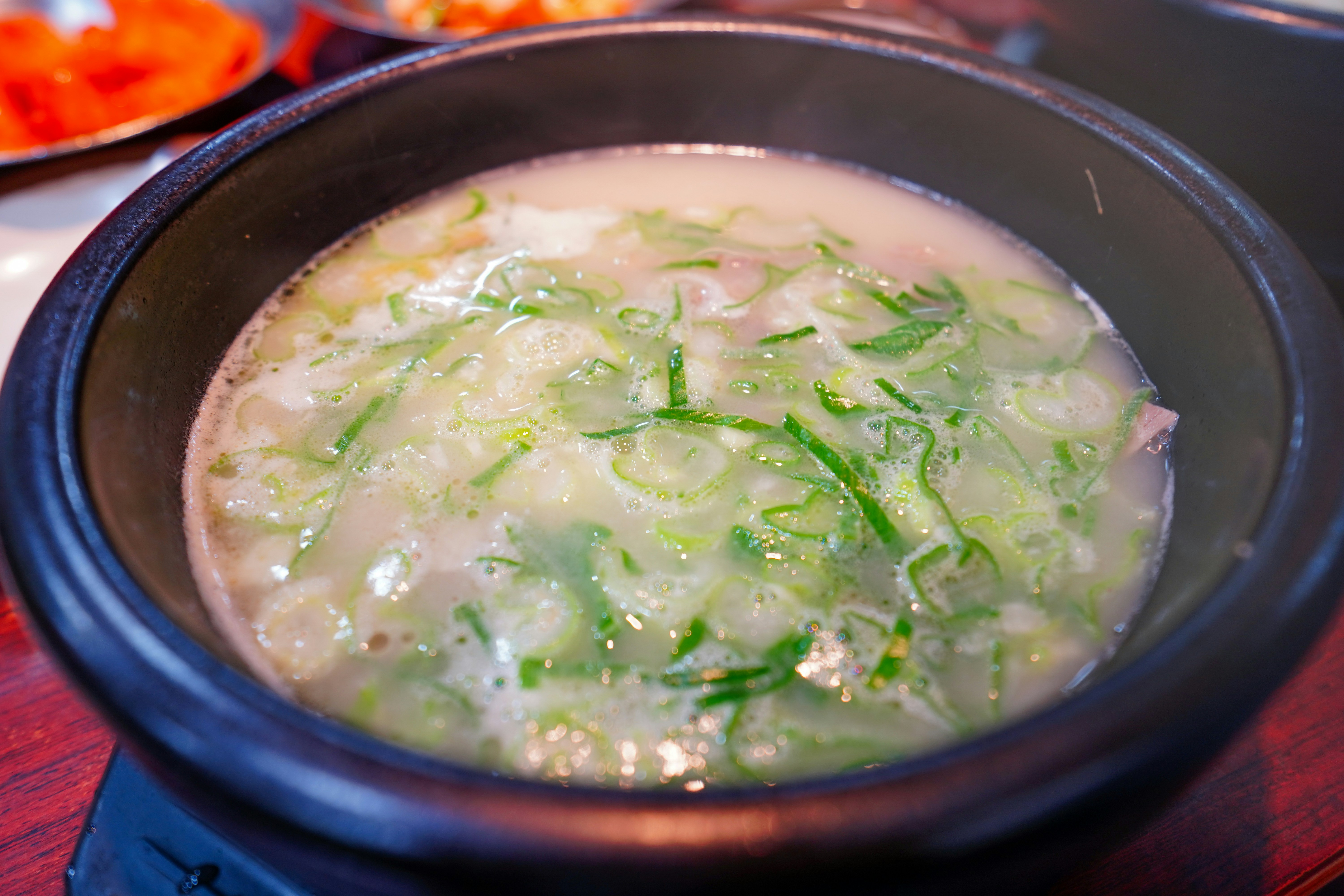 Creamy Herb-Studded Soup in a Dark Ceramic Bowl
