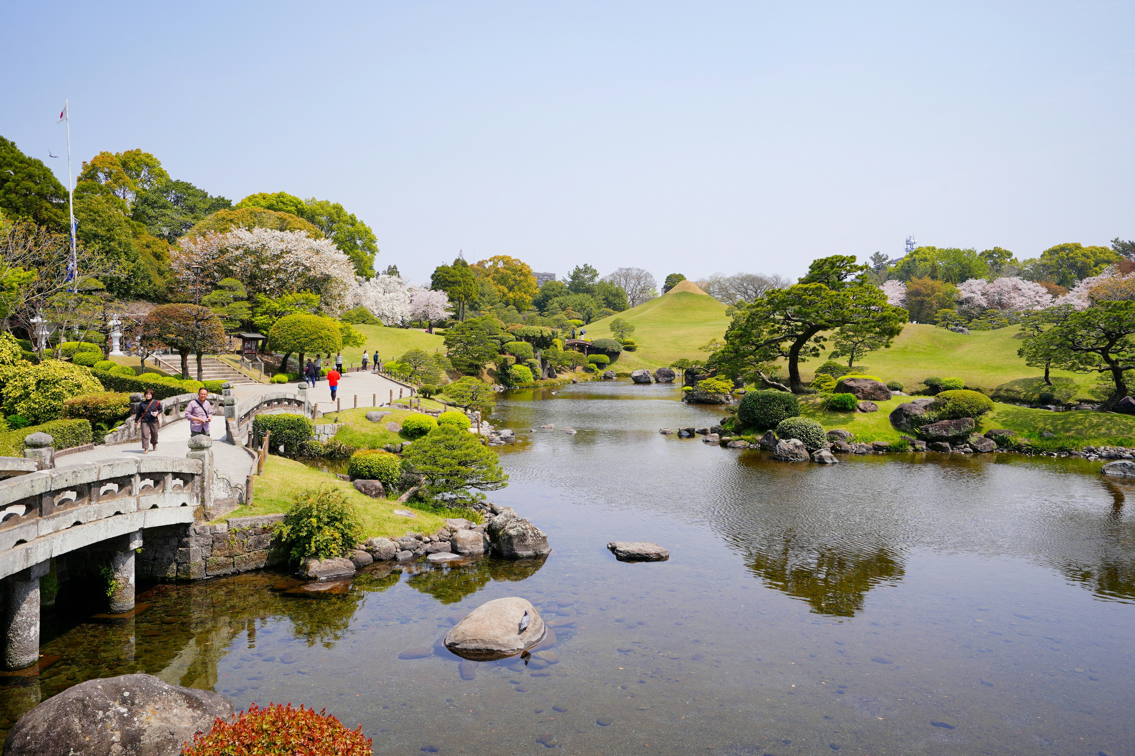 Serene Japanese Garden Over a Reflective Pond with Stone Bridge