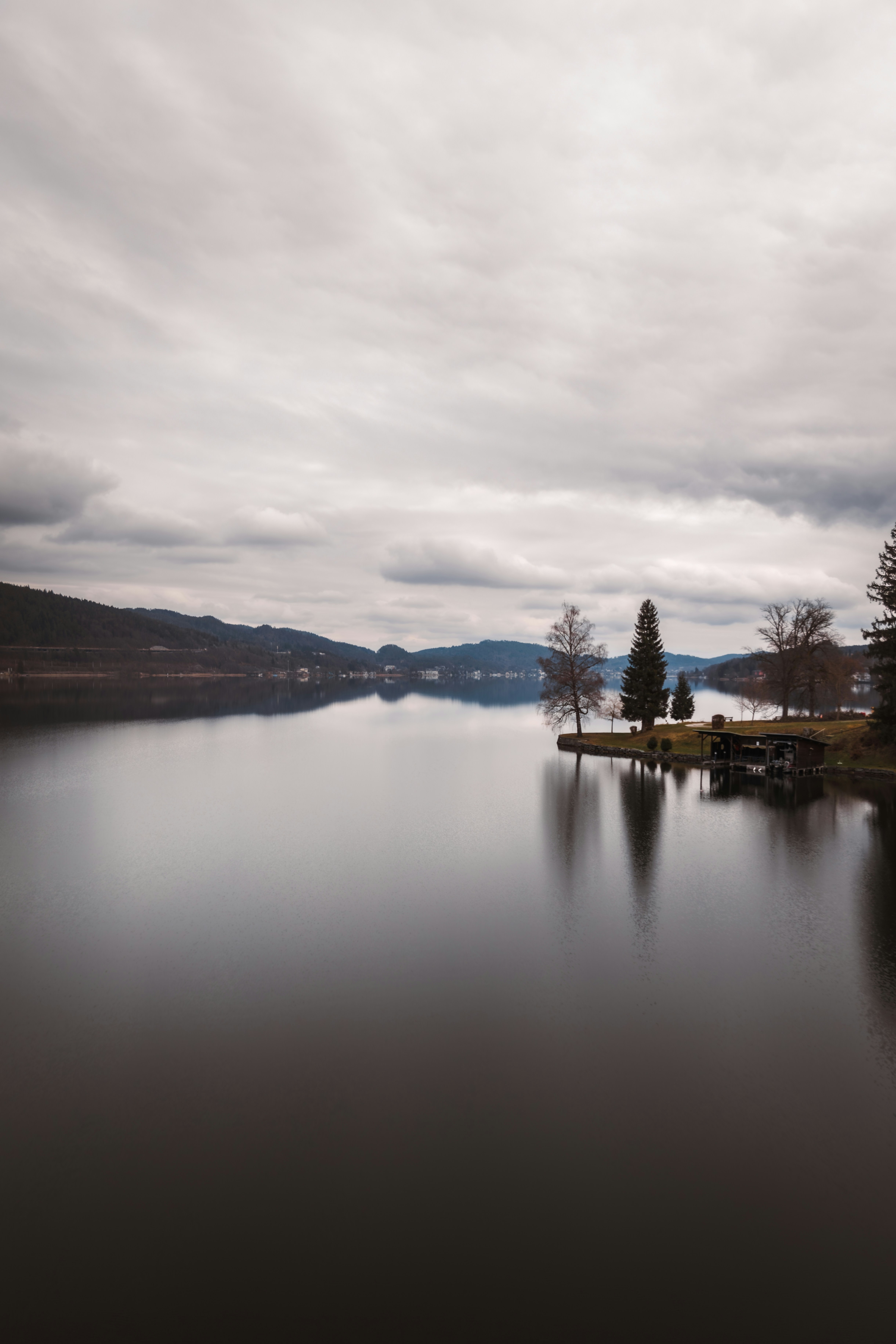 Still mountain lake with dock and trees on peninsula