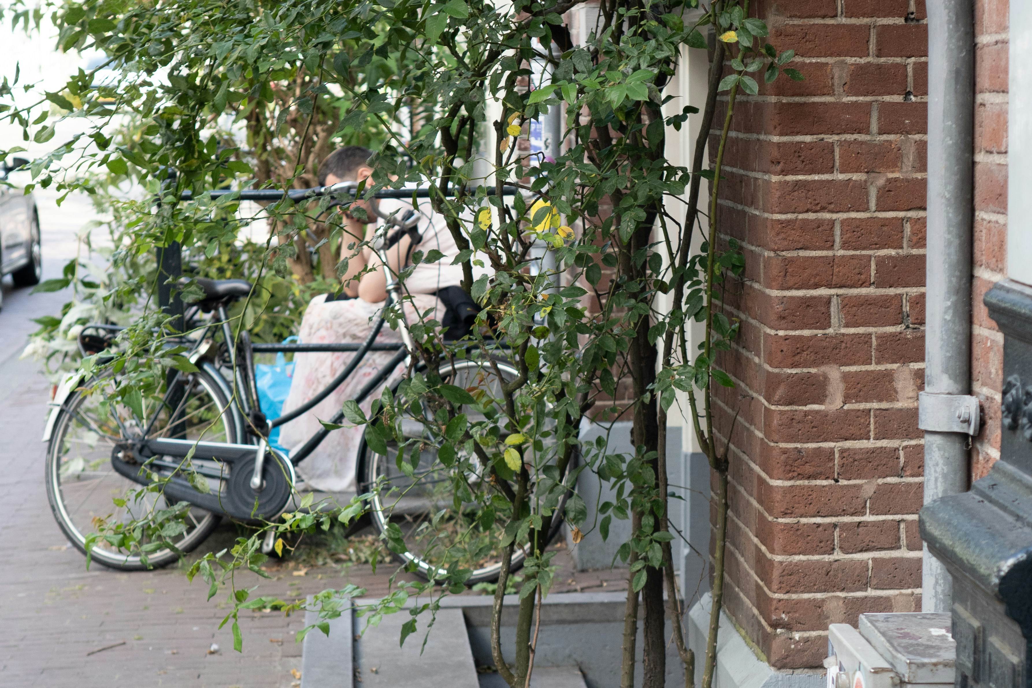 Quiet Street Corner: Bicycle, Wall, and a Distant Portrait