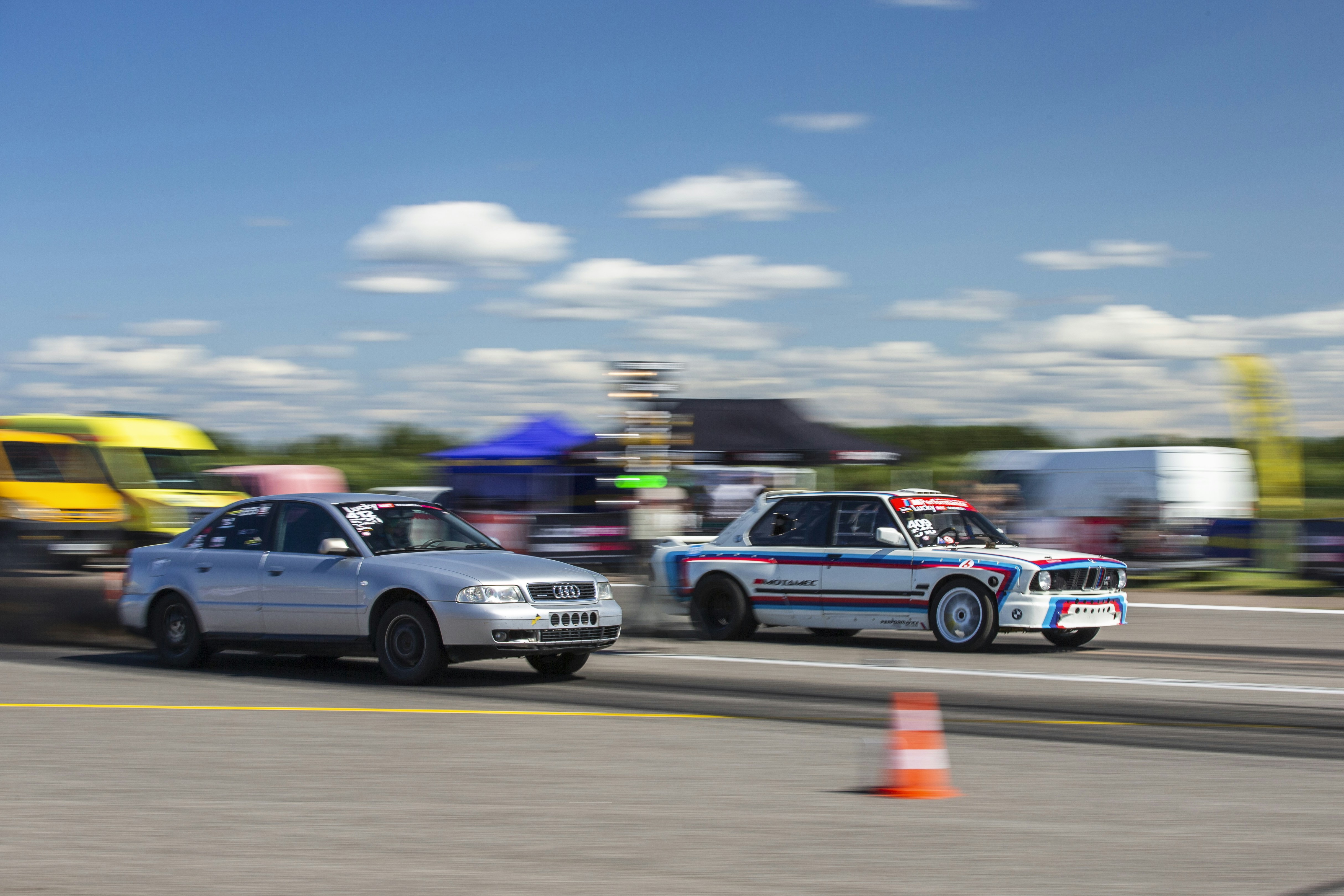 Two Race-Saluting Sedans Slide Past in a Blurred Runway Sprint