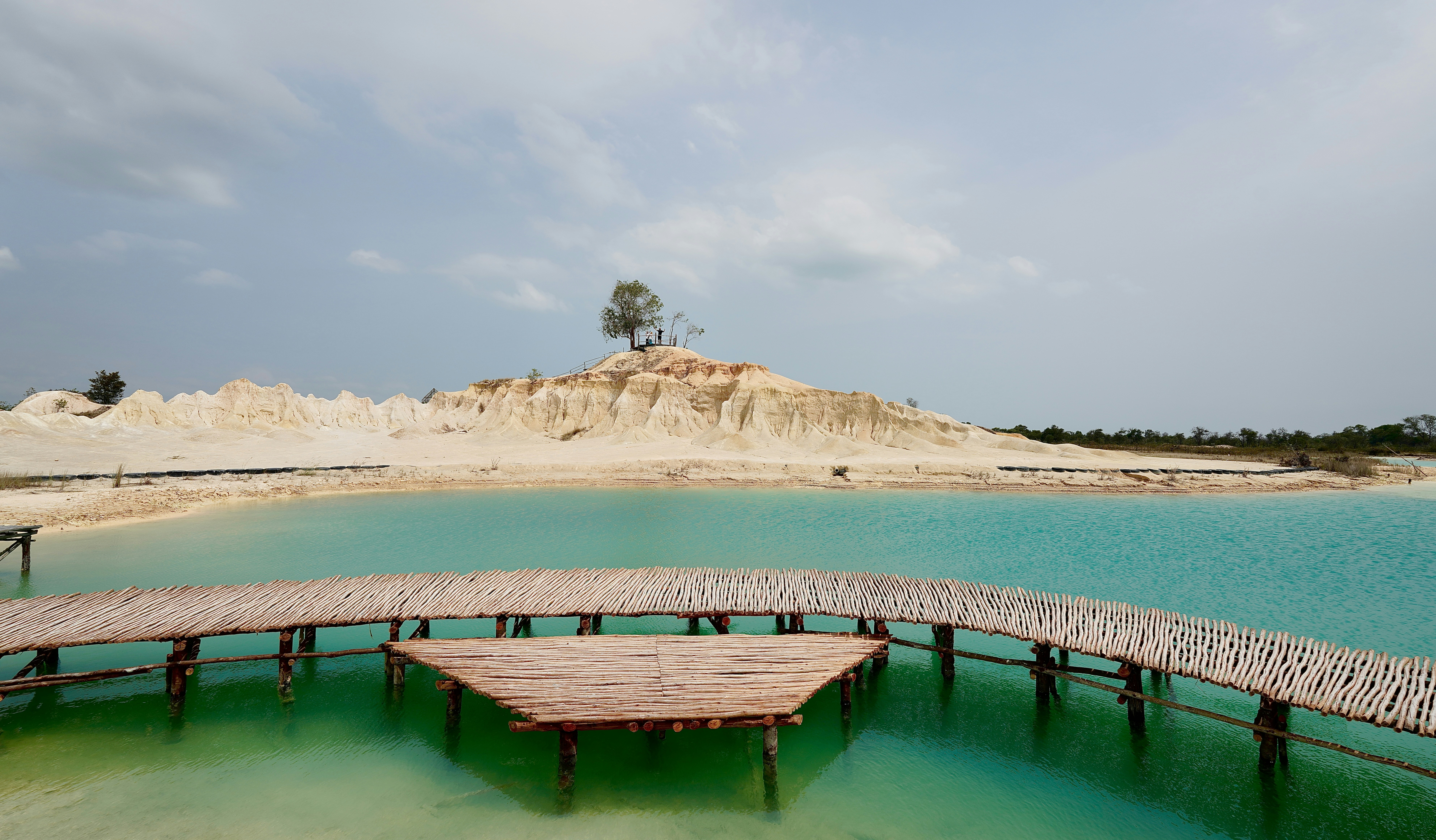 Turquoise Lagoon and Wooden Walkway Framed by Sandy Promontory