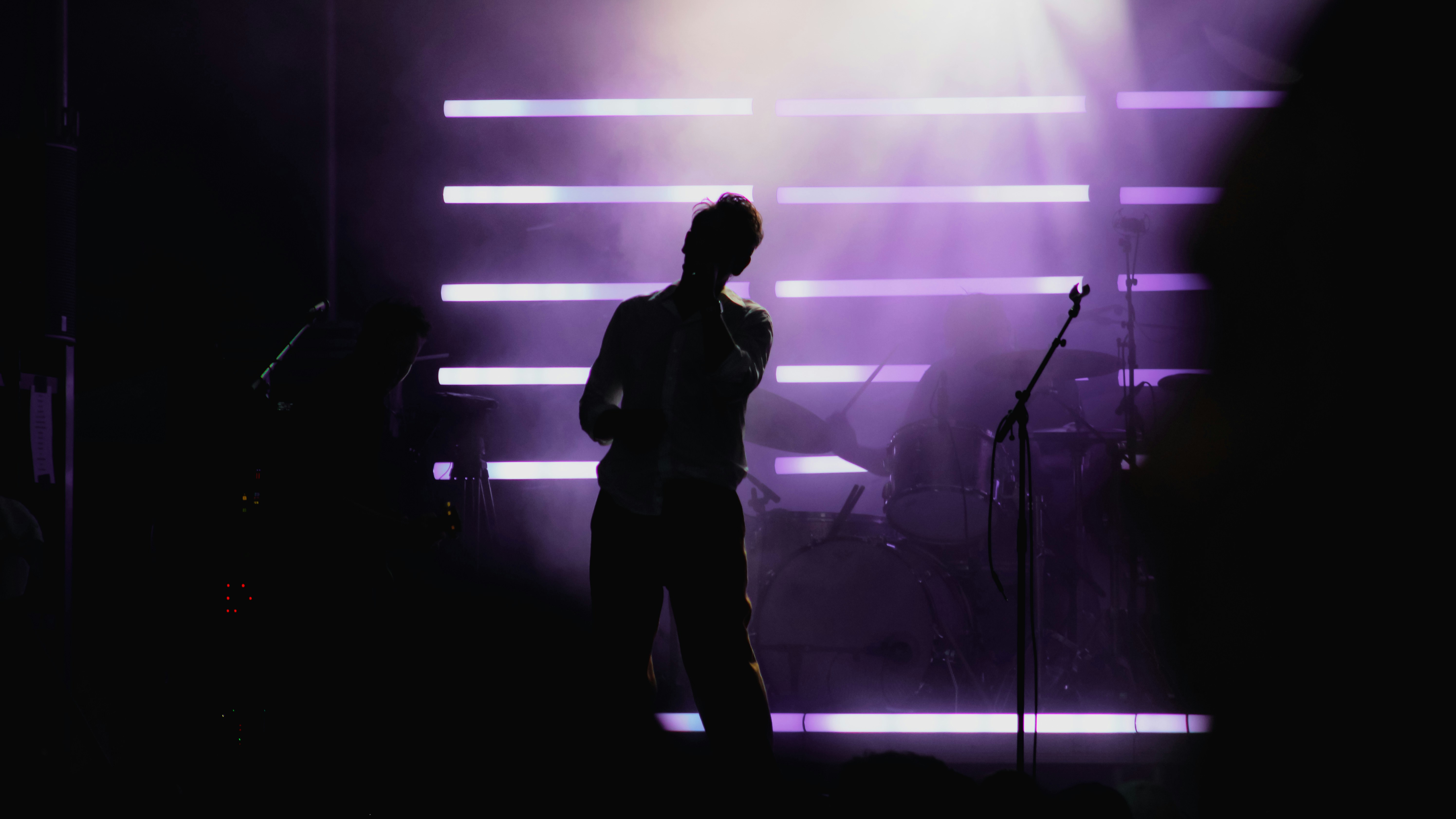 Midnight silhouette: a lone frontman bathed in neon lines