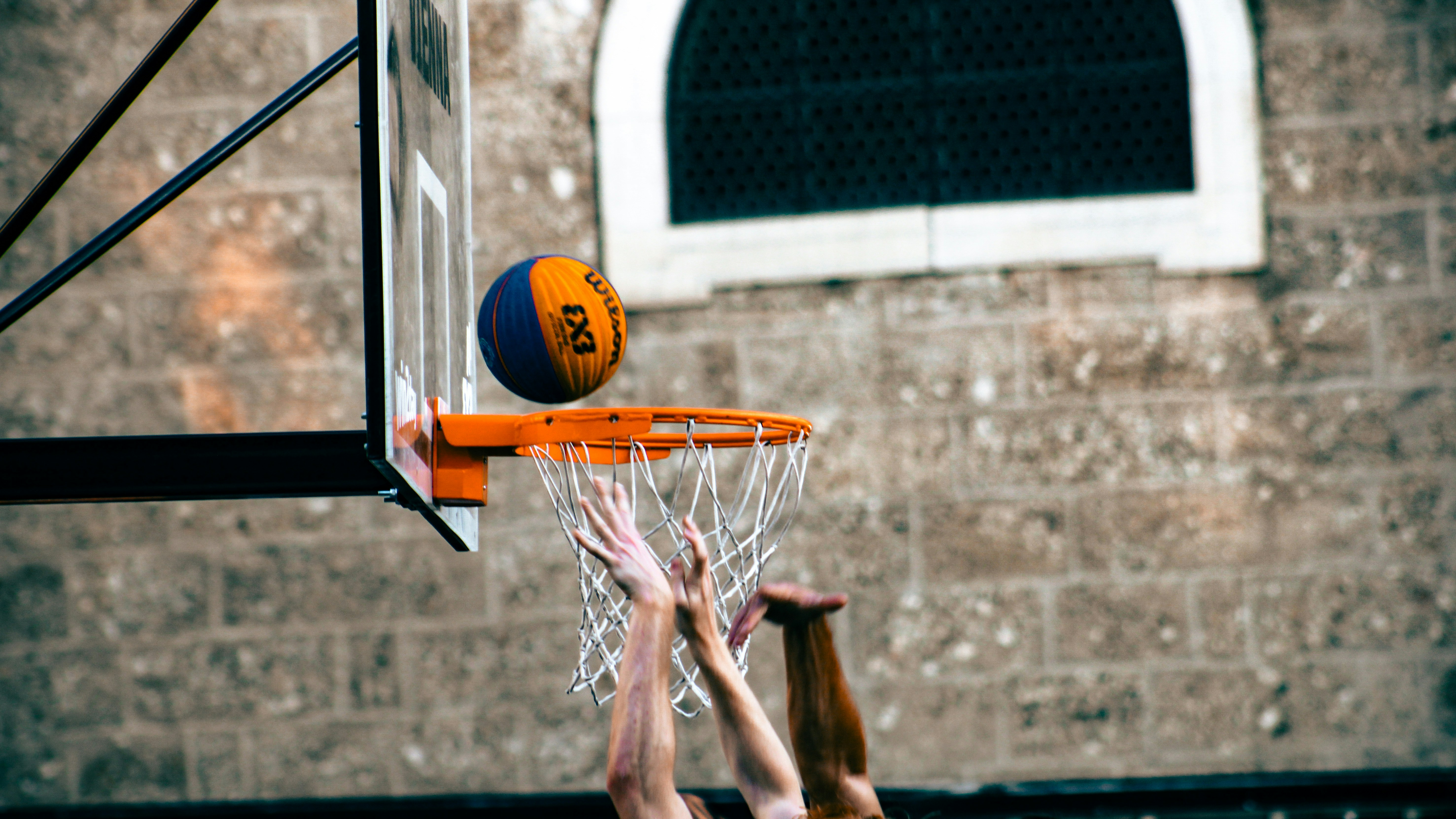 Ball soars toward the hoop against a weathered backboard