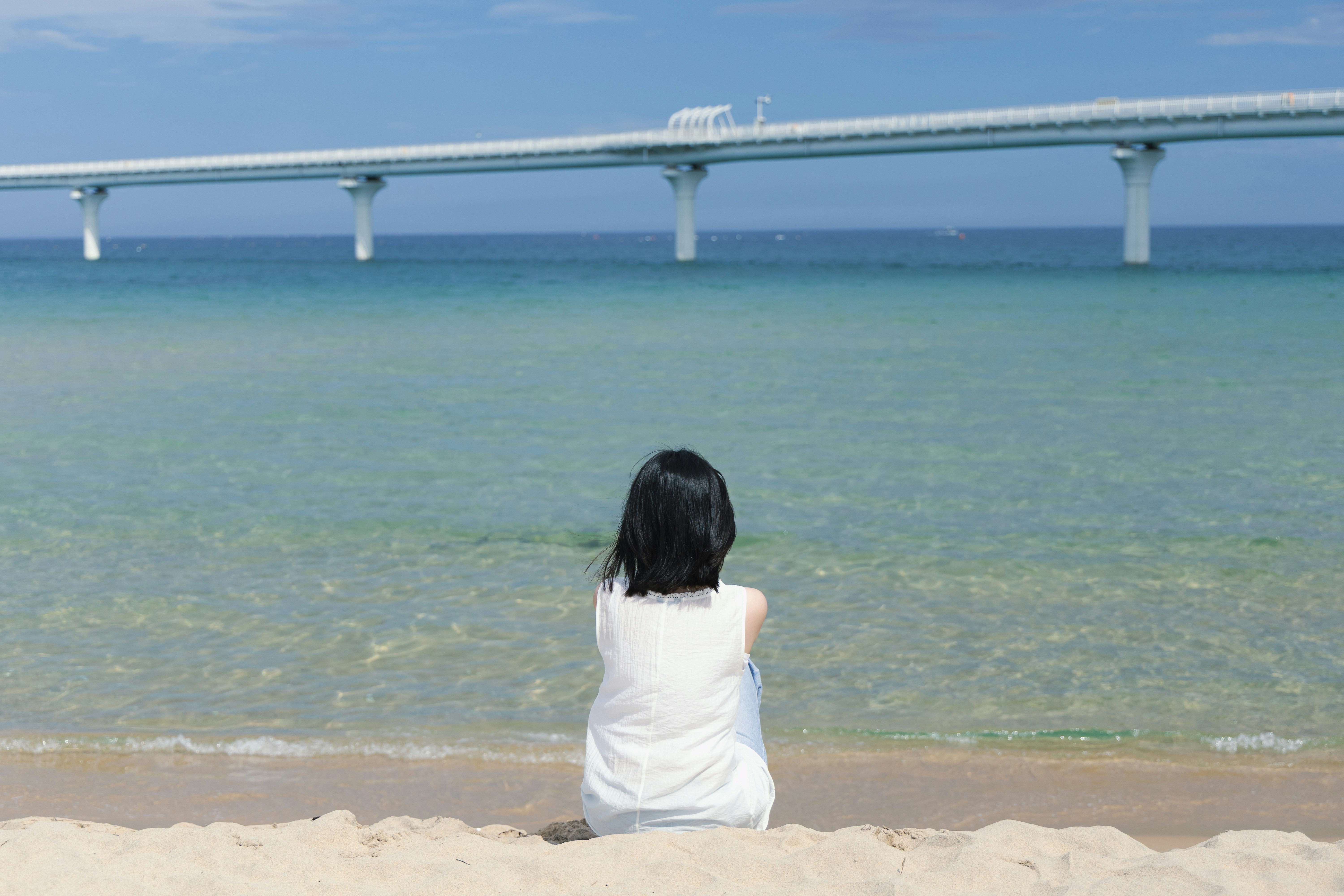  solitary shoreline: a lone figure in white gazes toward a turquoise horizon