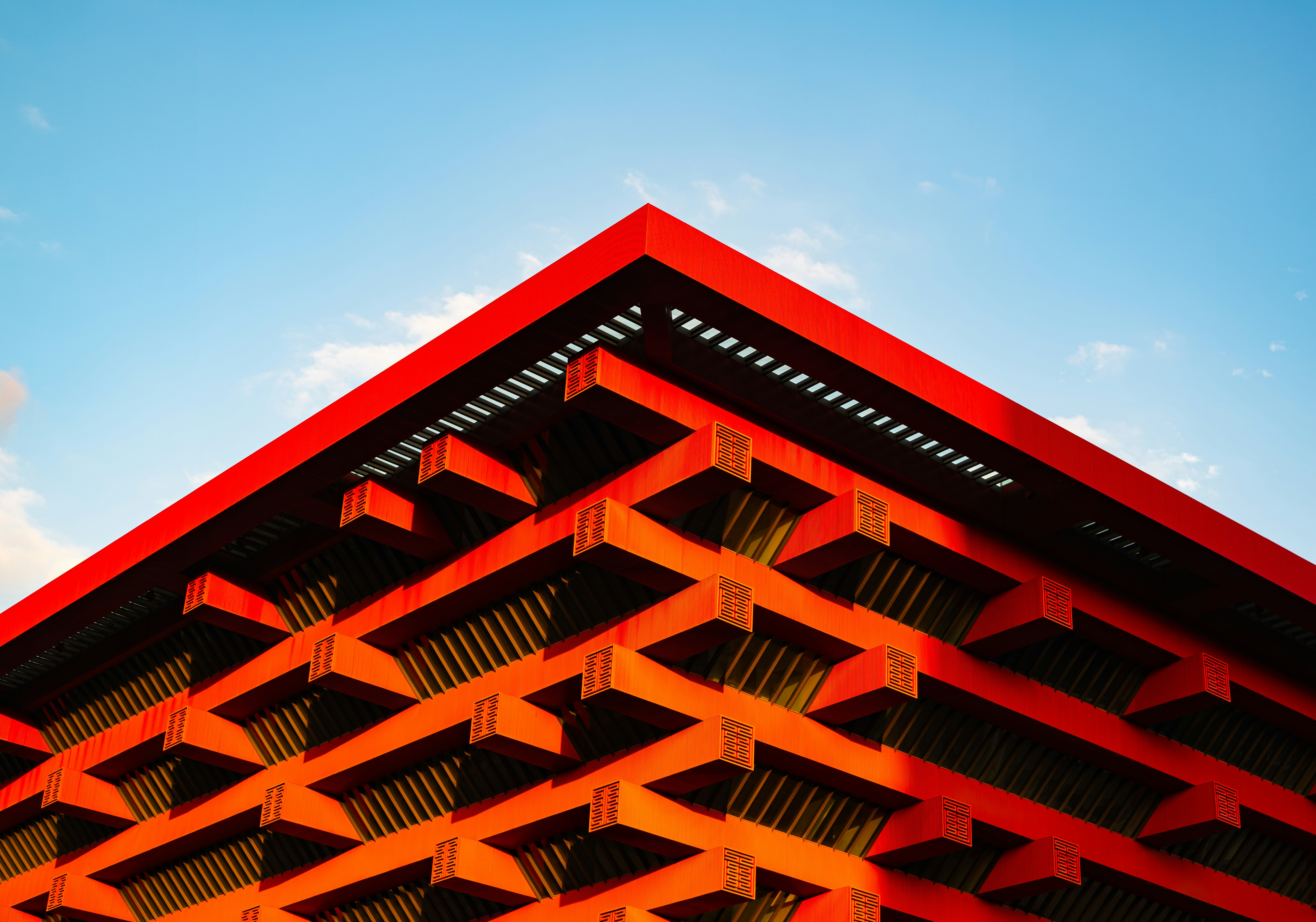 Red Lattice Overhang: Geometric Harmony in a Modern Facade