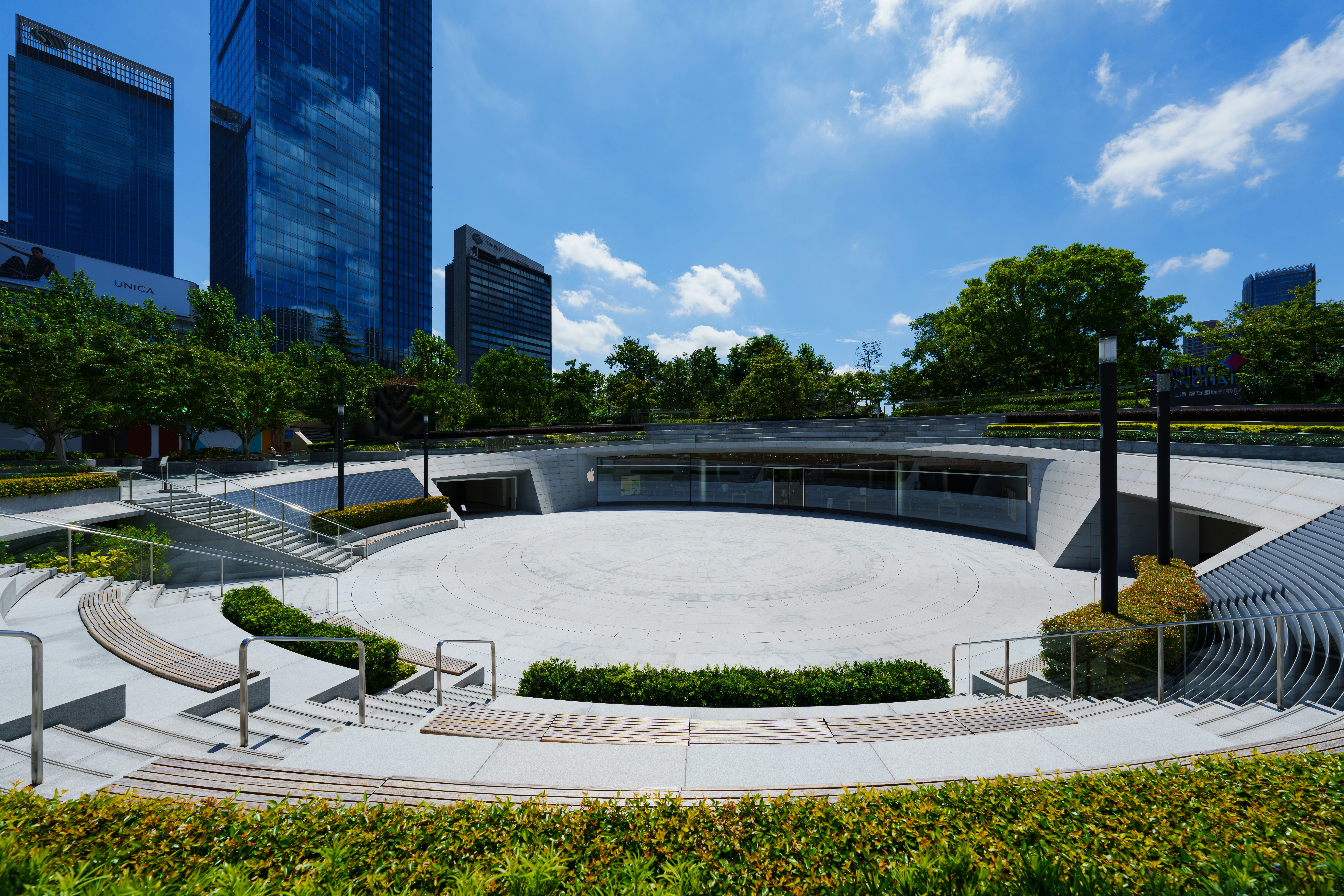 Circular concrete amphitheater under a cityscape of glass towers