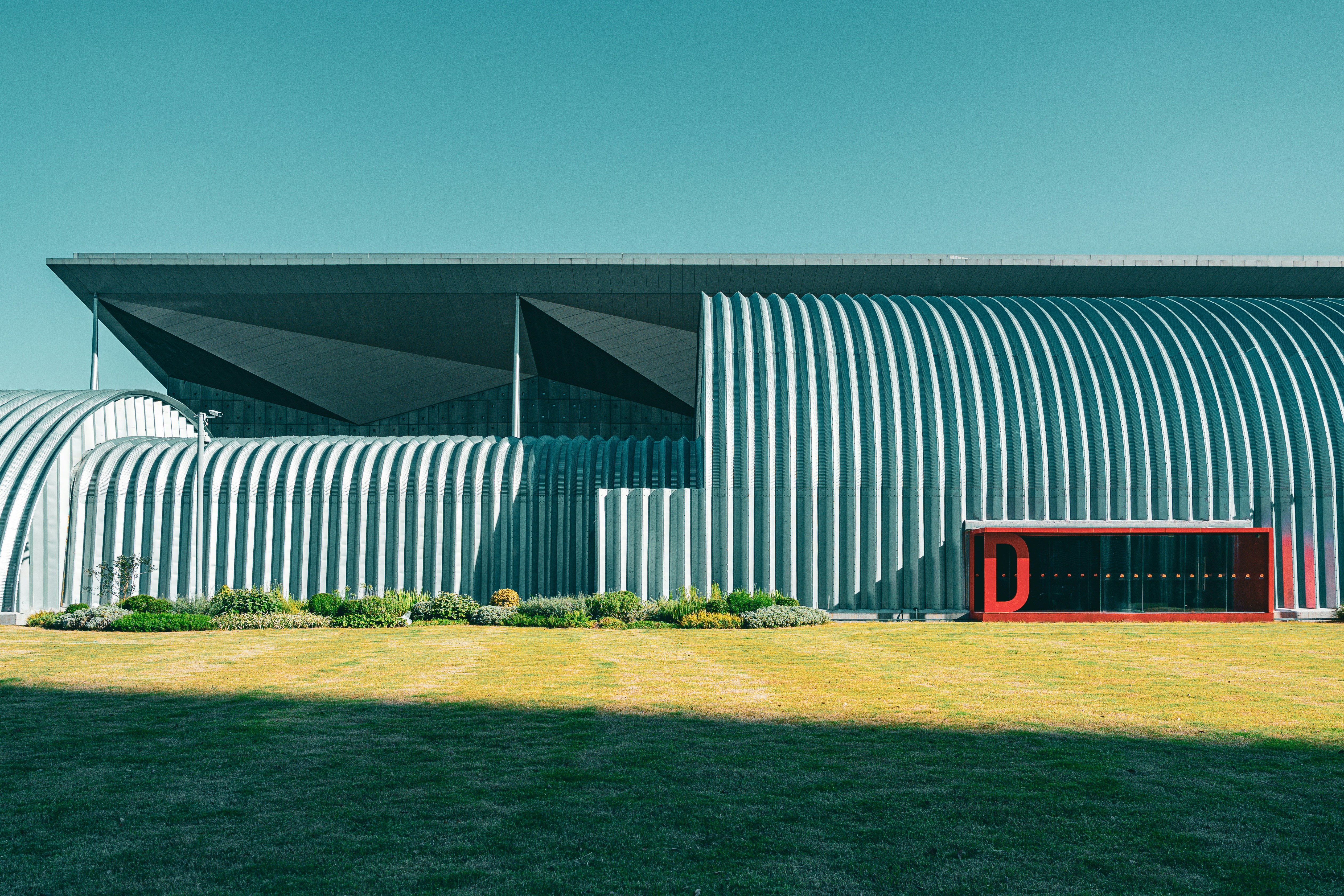 Ribbed Modernity: A Sunlit Facade of Industrial Architecture