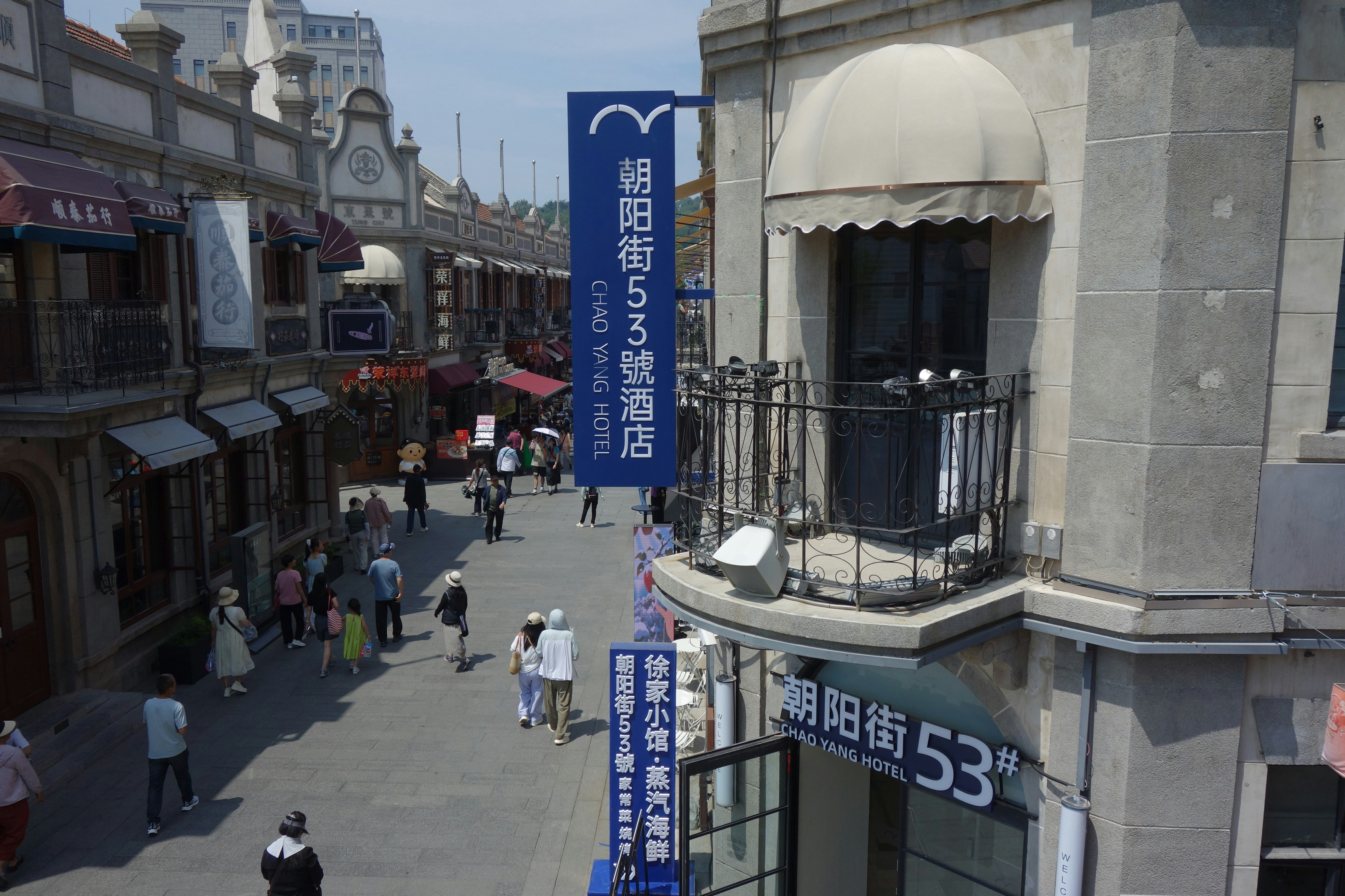 A lively street in a colonial-inspired shopping district with bold blue signage