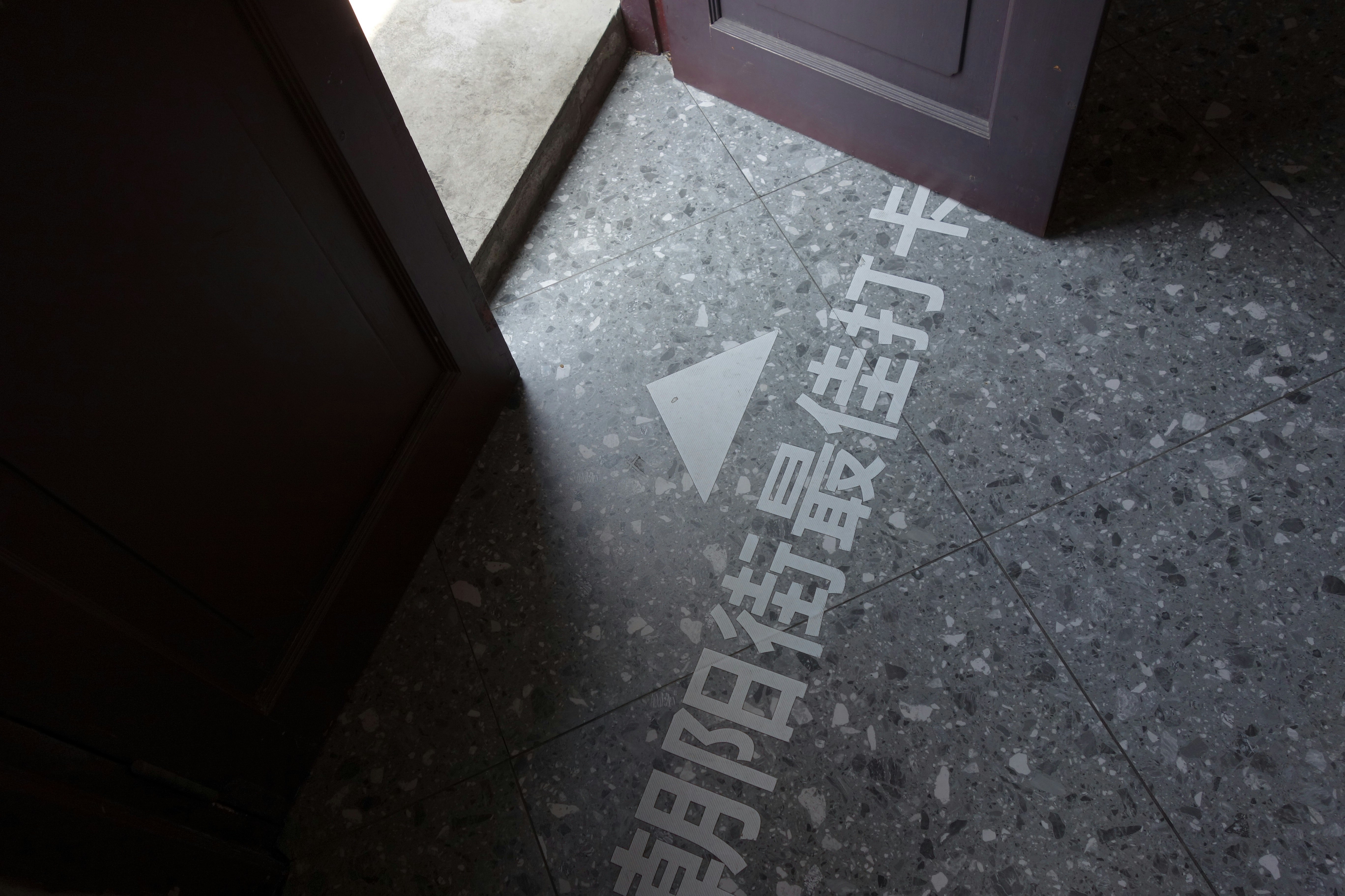 Entrance Marker: The Bold Arrow and Chinese Text on Polished Floor