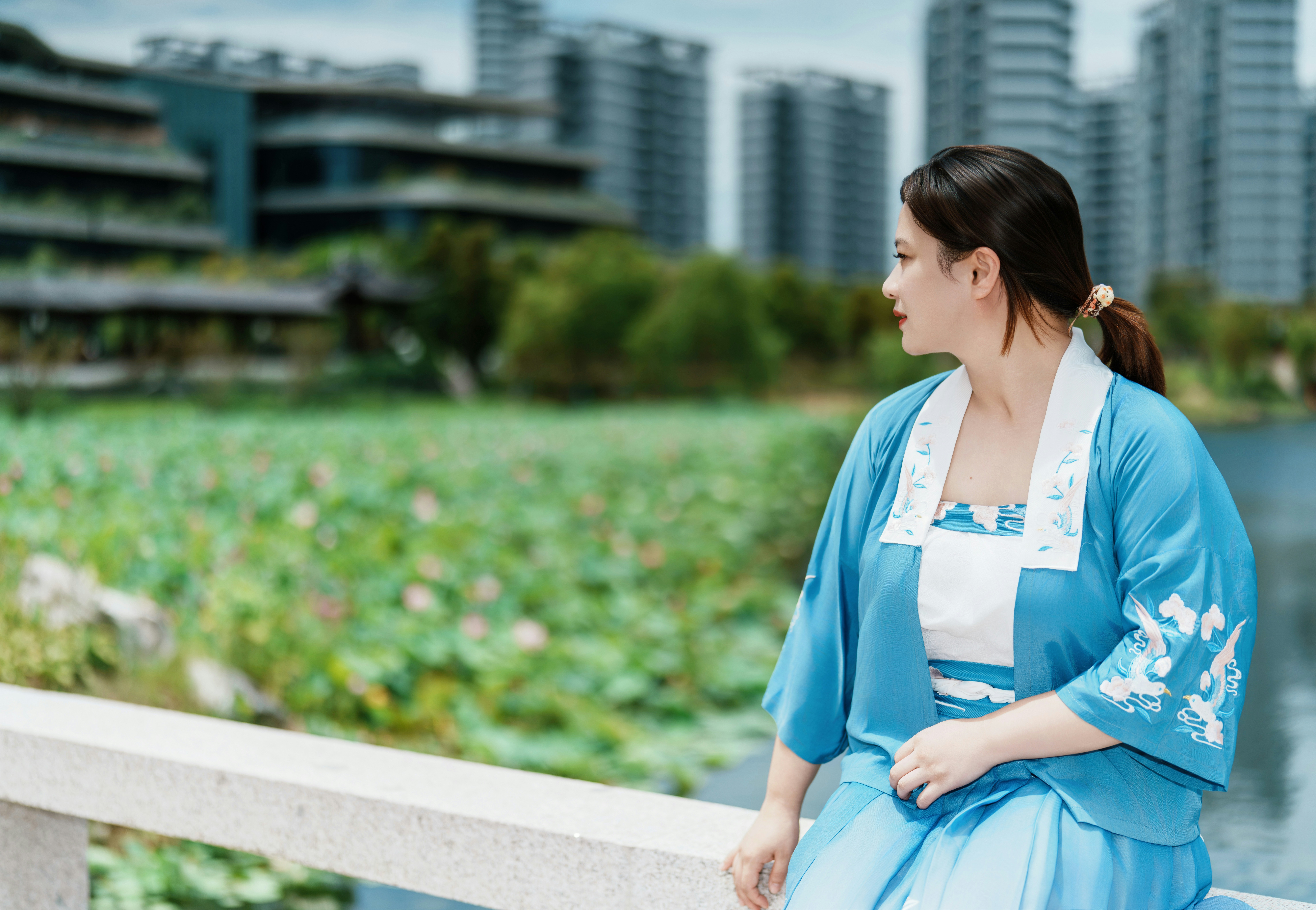 Blue Kimono by the Water: Quiet Contemplation Amid Urban Lilies