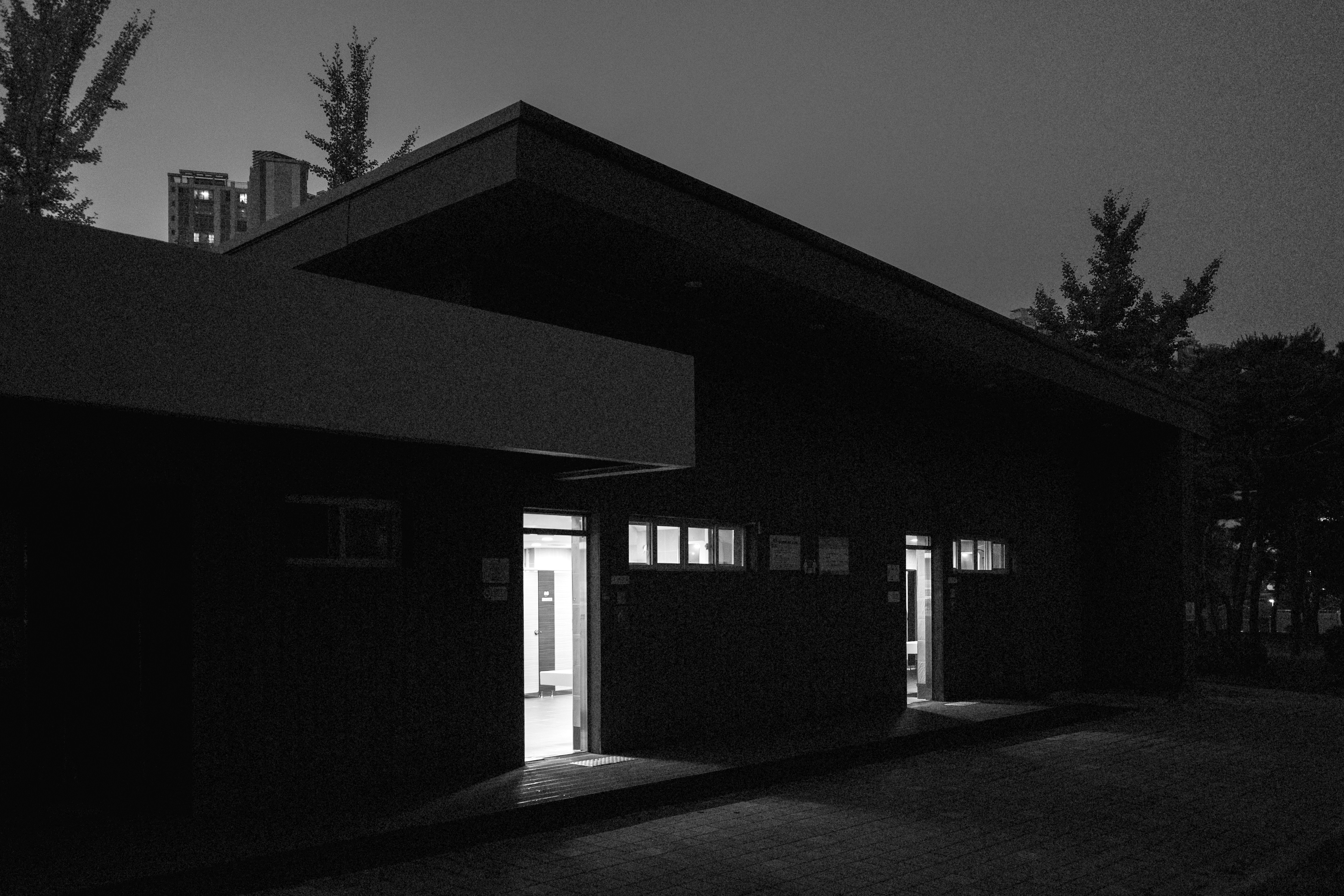 Night Entrance: Quiet Campus Corridor Glowing through Open Doors