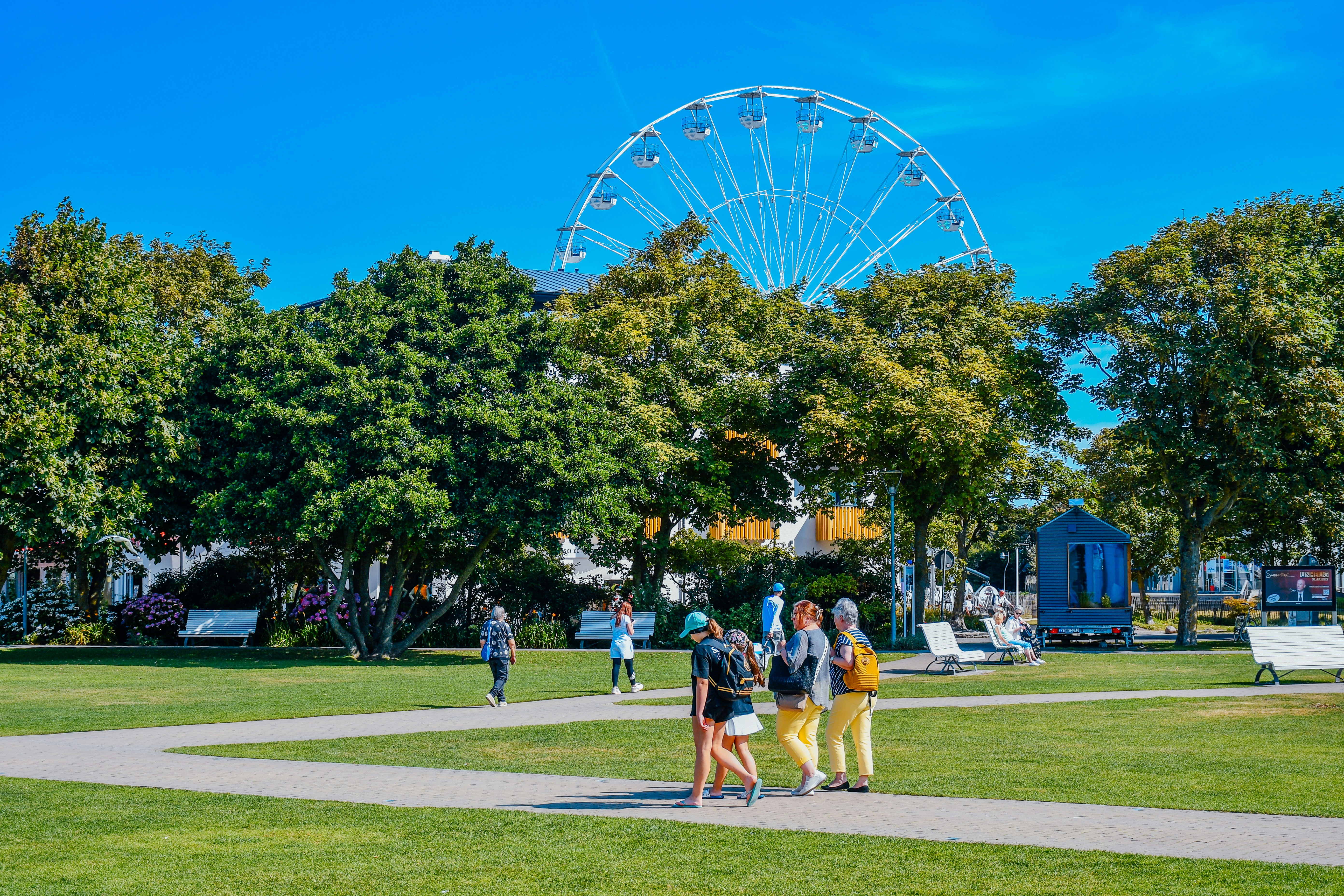Laughter in the Park: A Family Moment Beneath a Skyward Wheel
