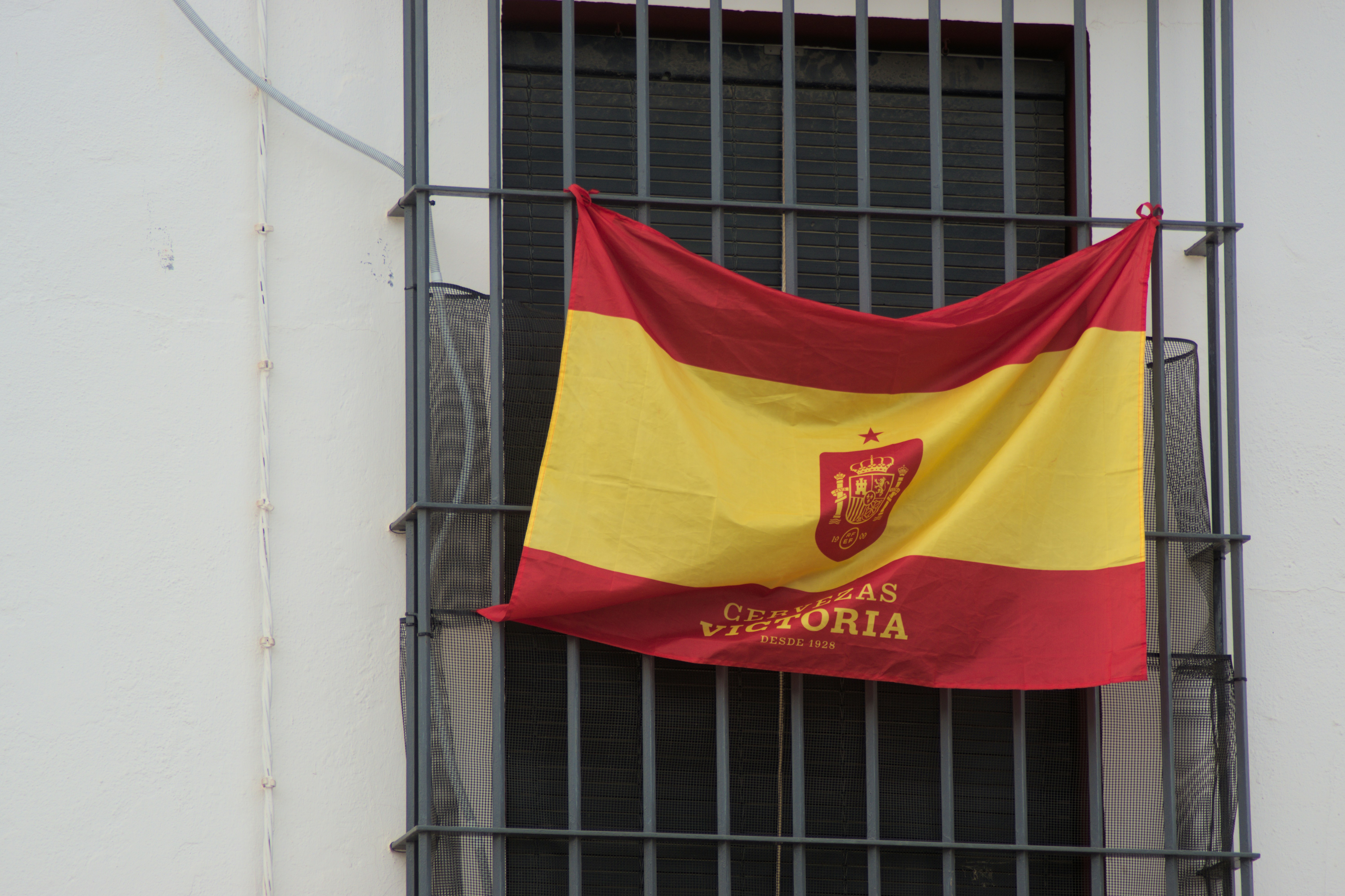 Flag of Spain Draped Over a Window Grill