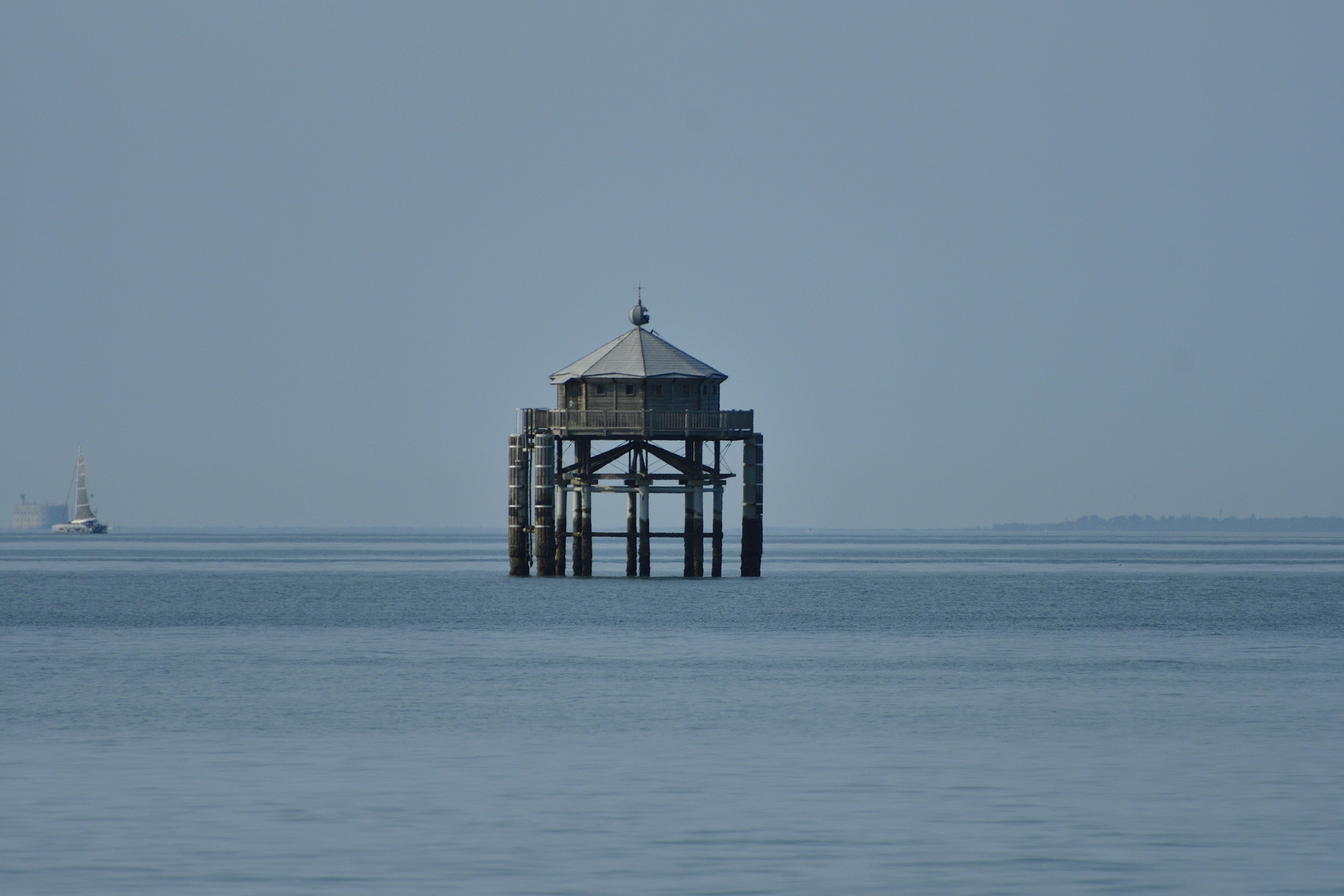 Beacon on stilts: a solitary coastal lookout against a calm horizon