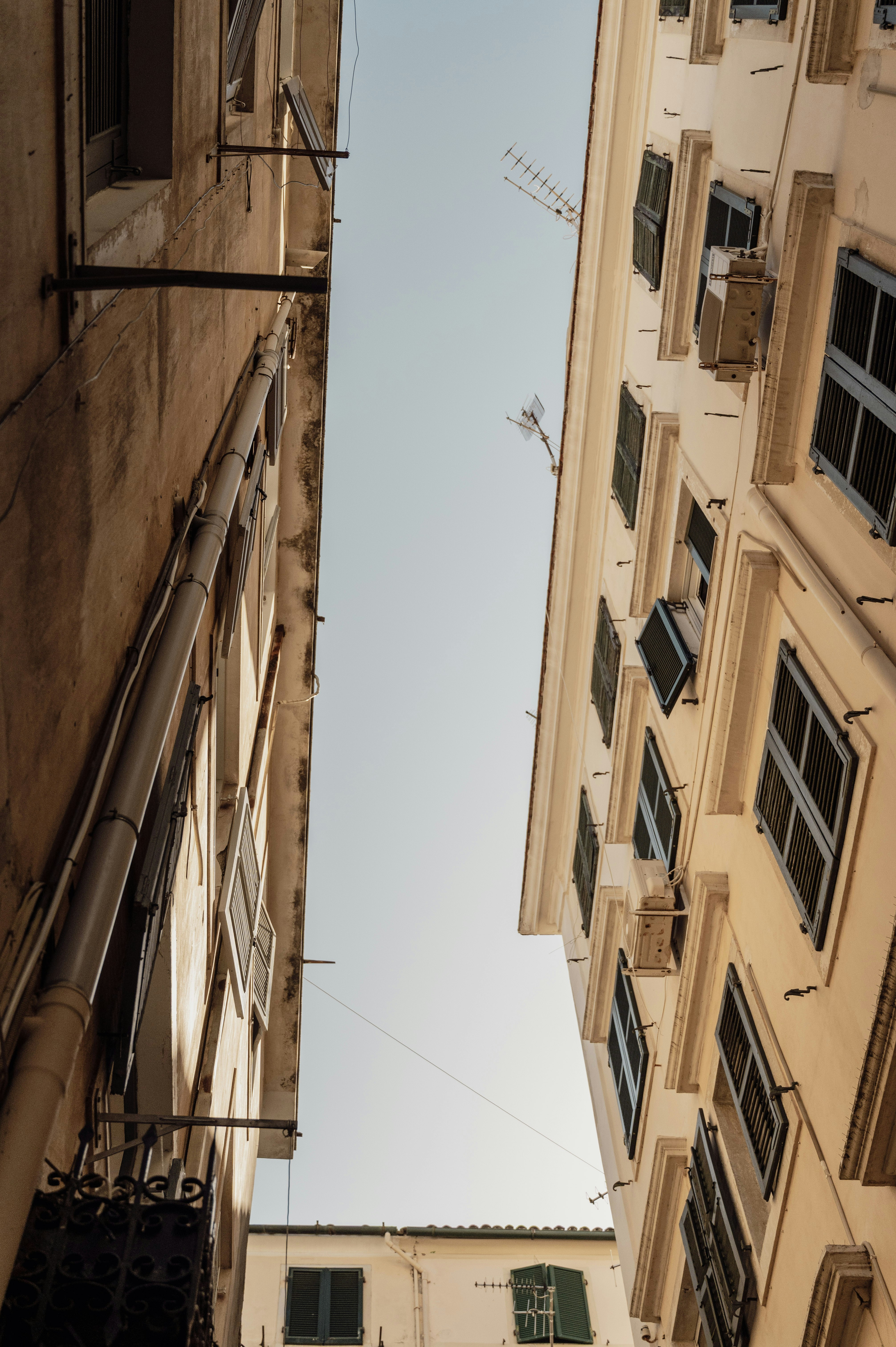 Urban Skyward: Narrow Canyon Between Sunlit Buildings
