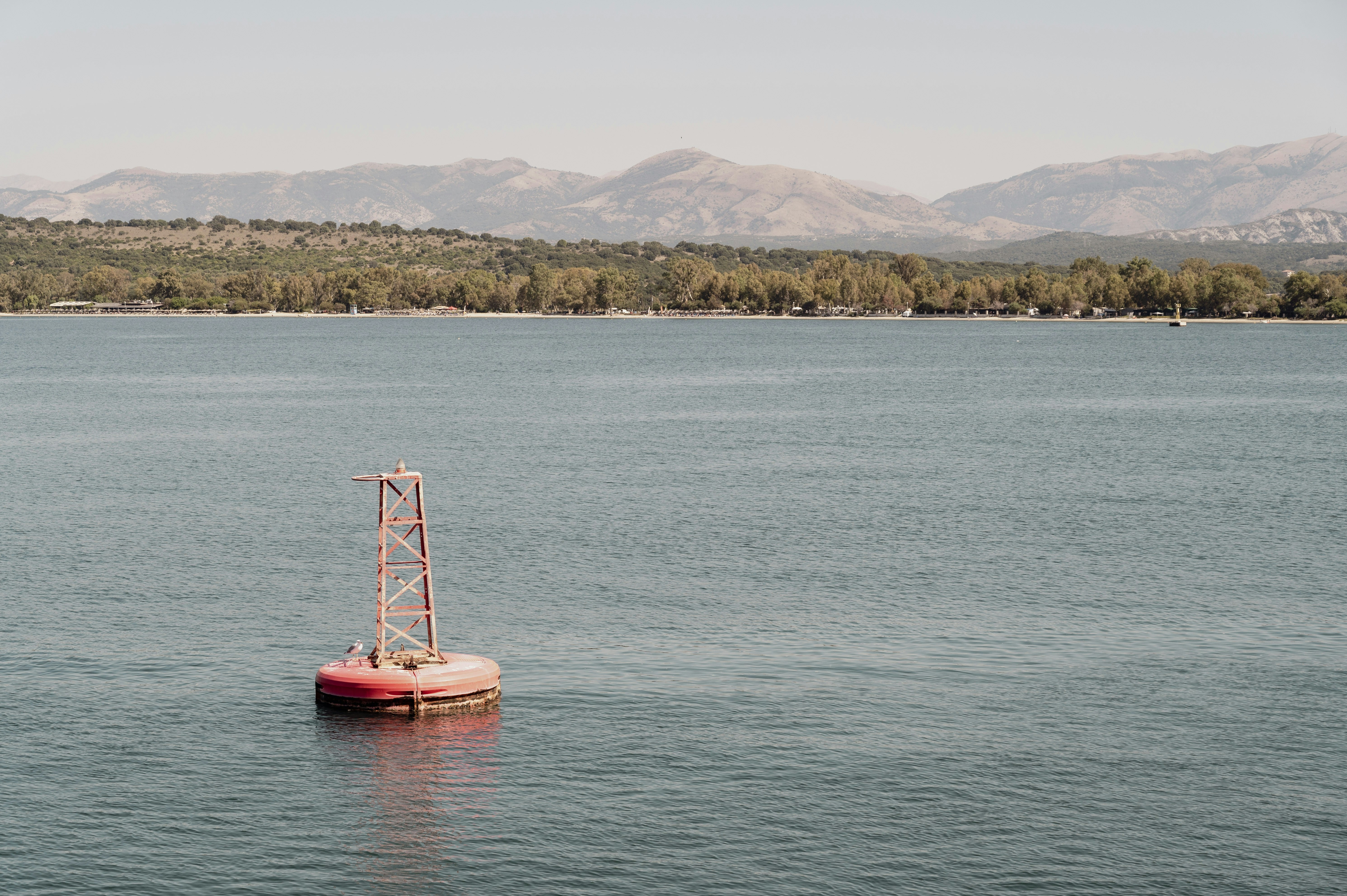 Red Buoy and Lighthouse Mast Quietly Marking the Lagoon
