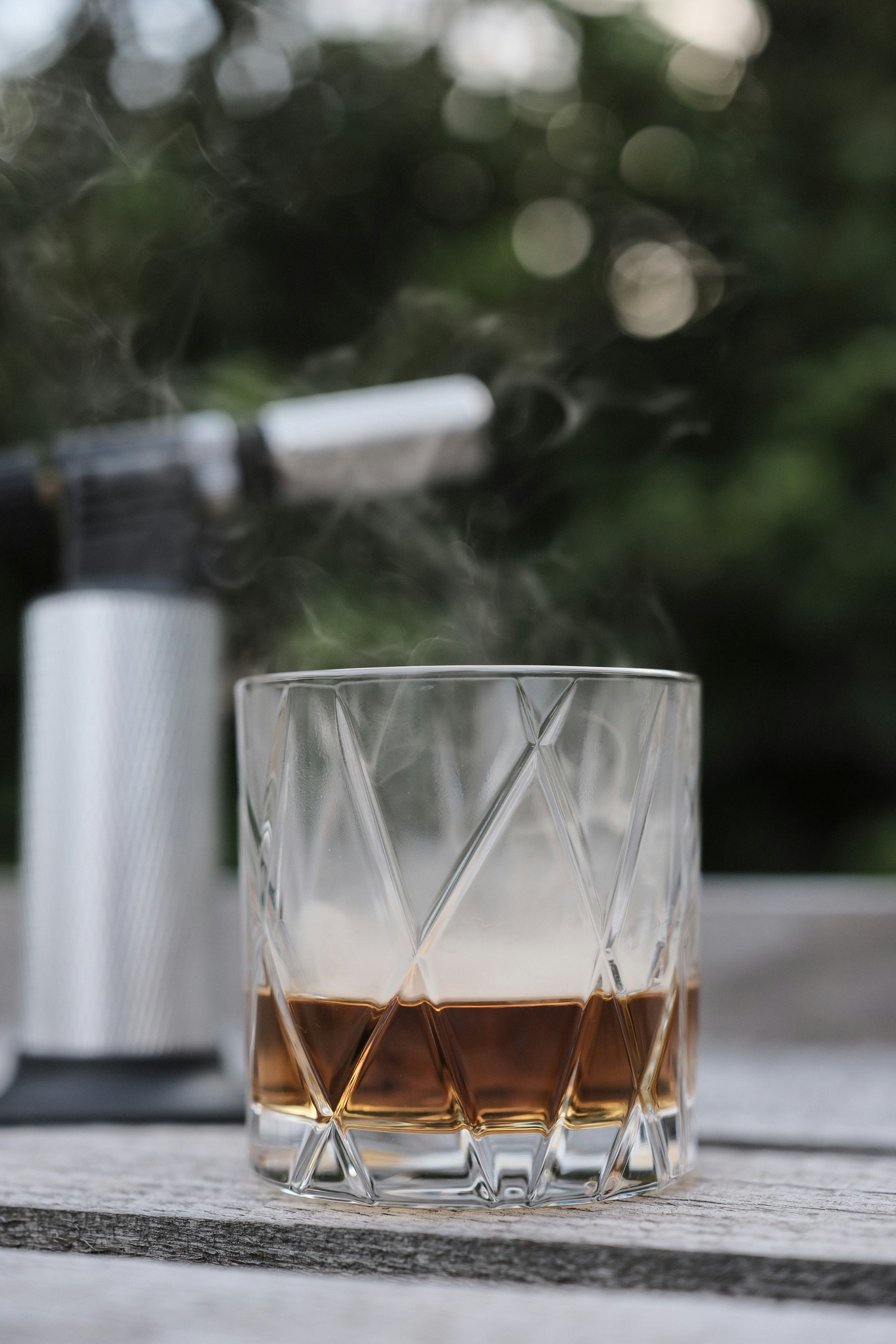 A glass of smoked whisky, with smoke coming out at the top.