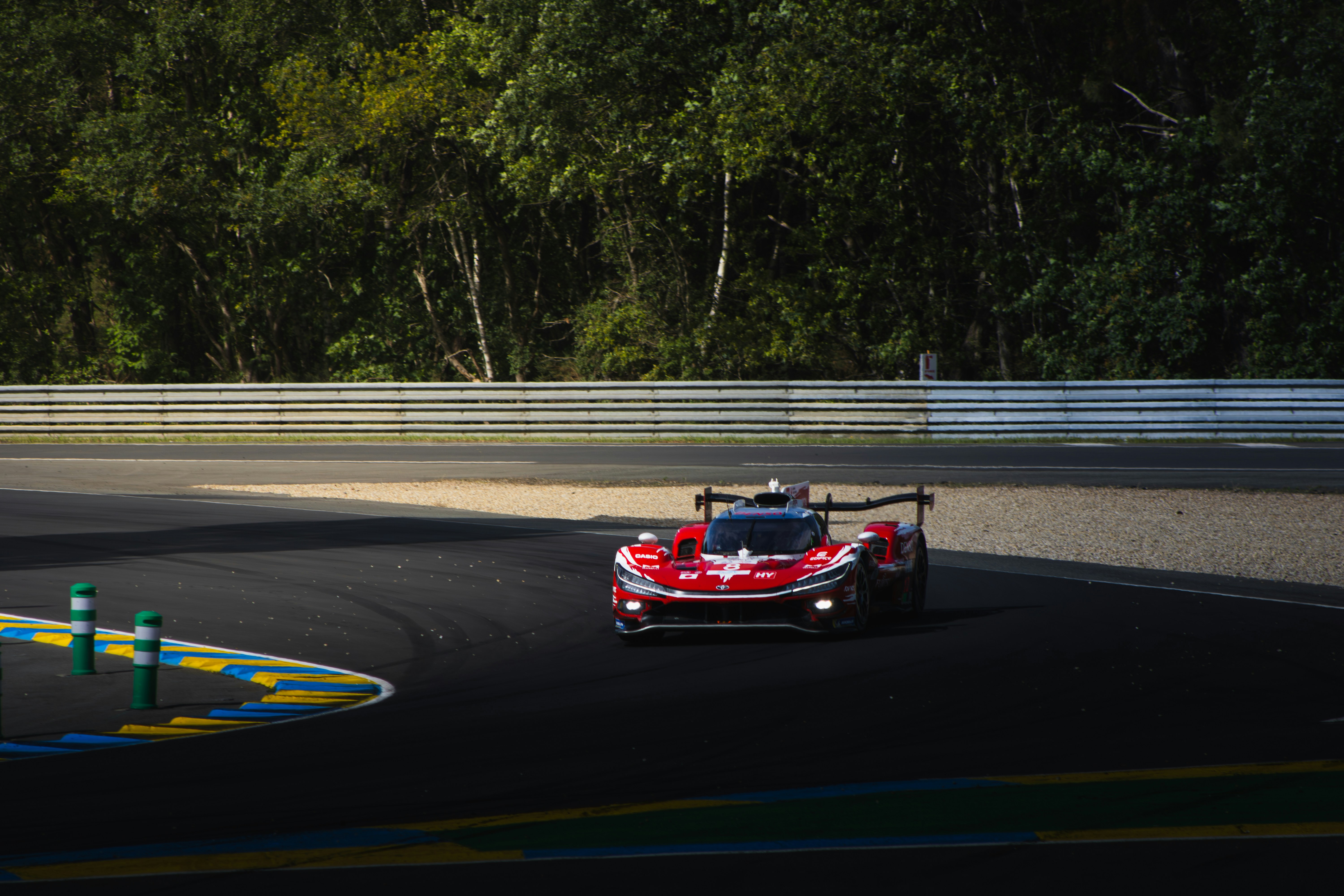 Red prototype sprinting through a daylight curve
