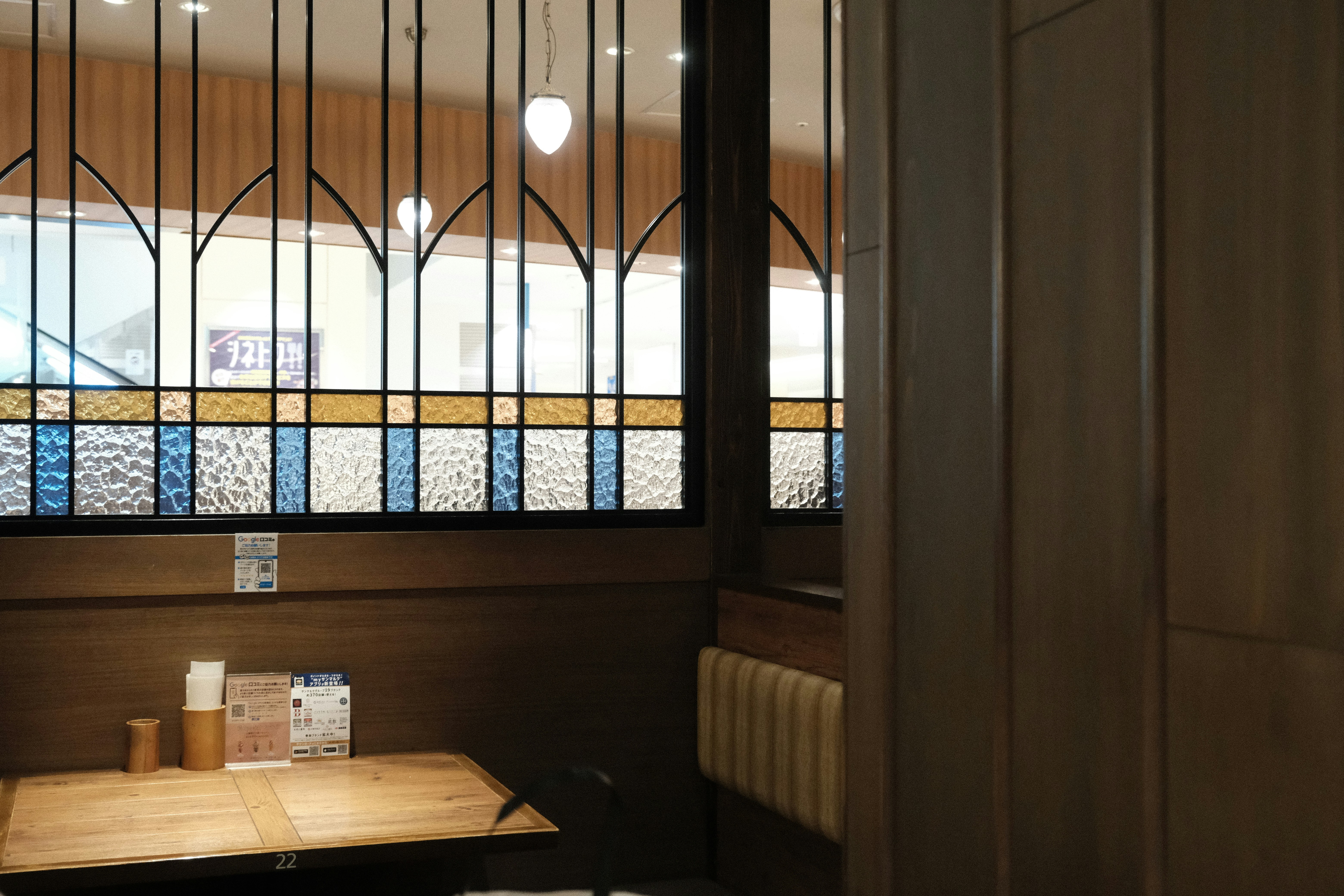 Quiet Corner: Warm Light, Arched Window and Wooded Booth