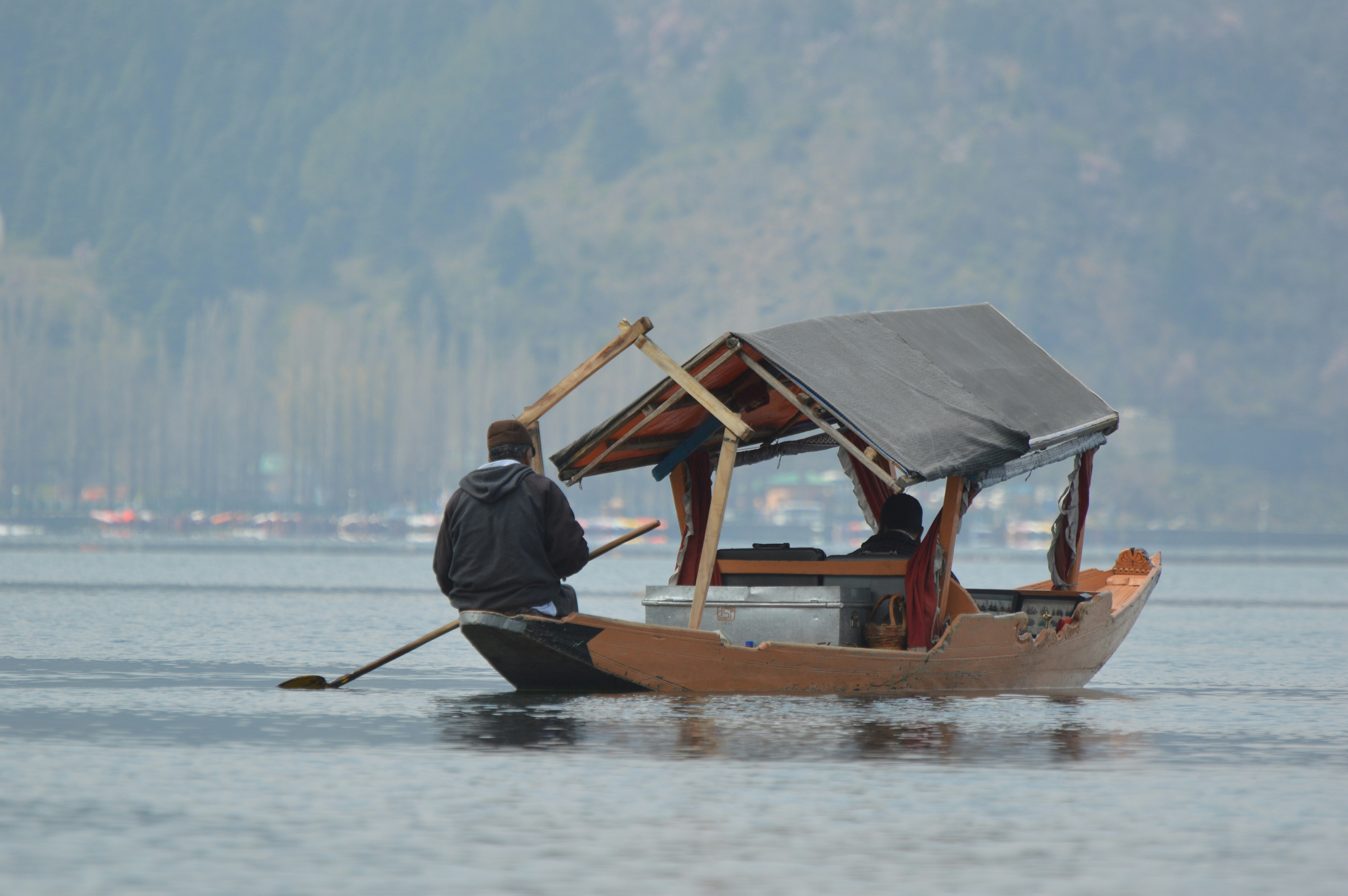 Boatman in Calm Waters: A Solitary Oar and Wooden Craft