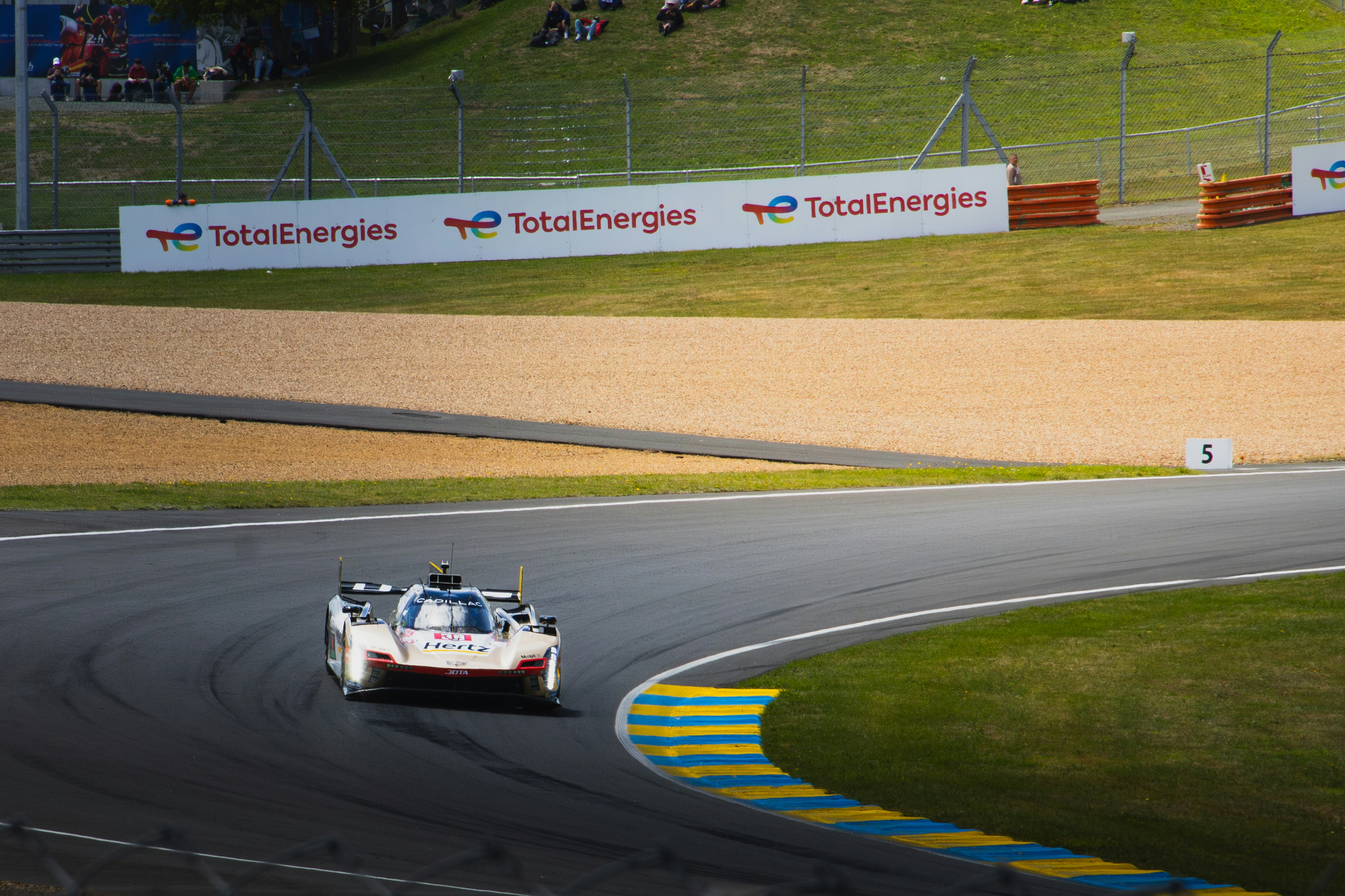 First Lap Focus: A Racing Car Navigates a Cresting Turn