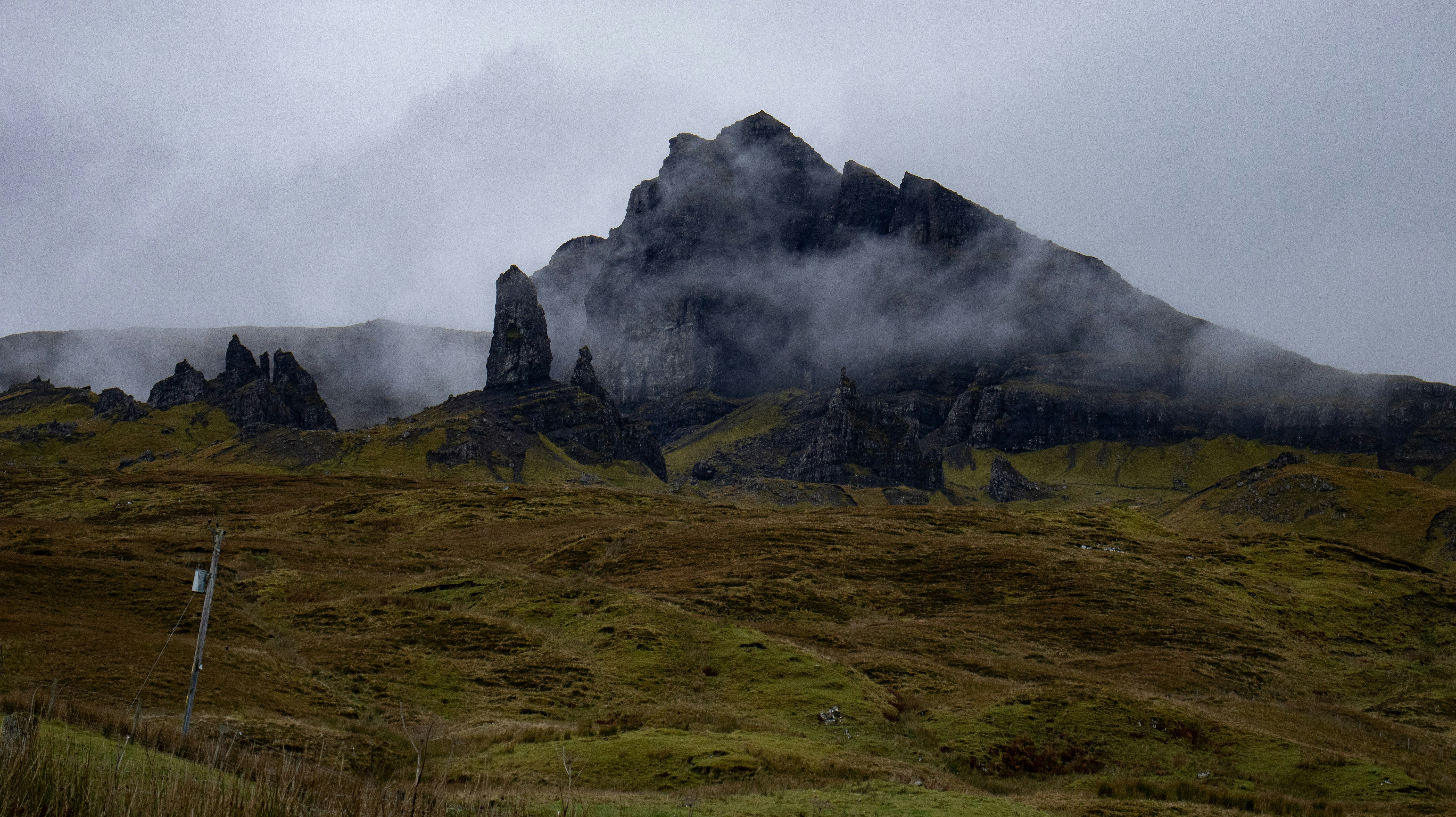 Mist-enshrouded Peak Rising Above a Rugged Moor